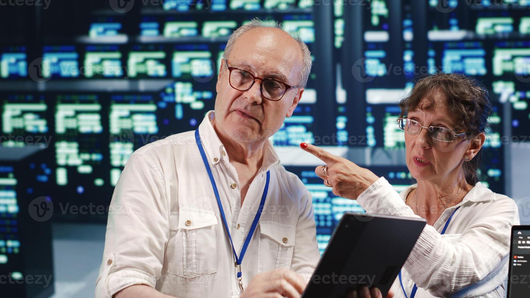 Software developers in high tech establishment, completing tasks on tablet while running scripts ...