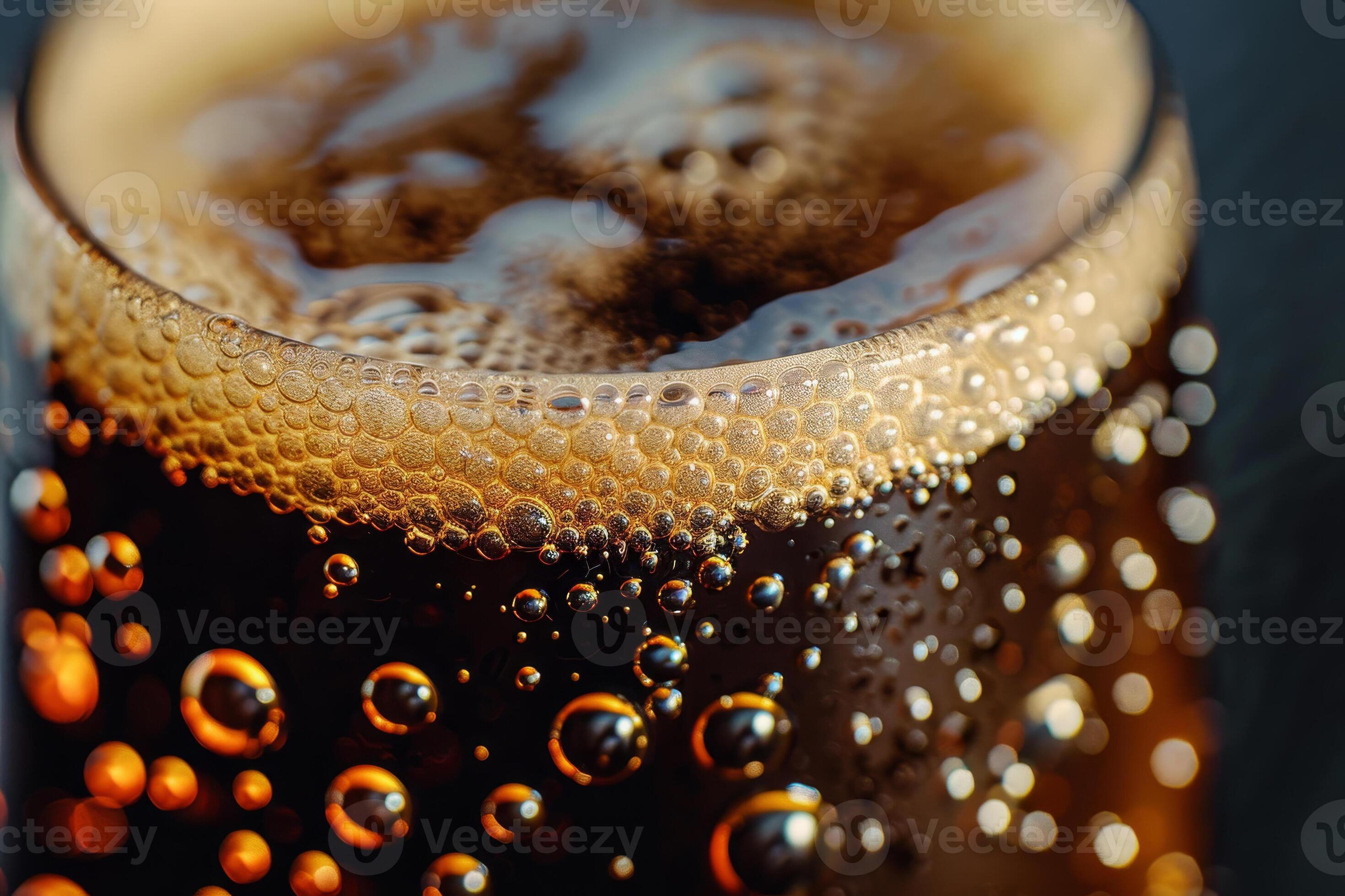 A glass filled with a dark, carbonated beverage reveals a cascade of bubbles creating a frothy ...