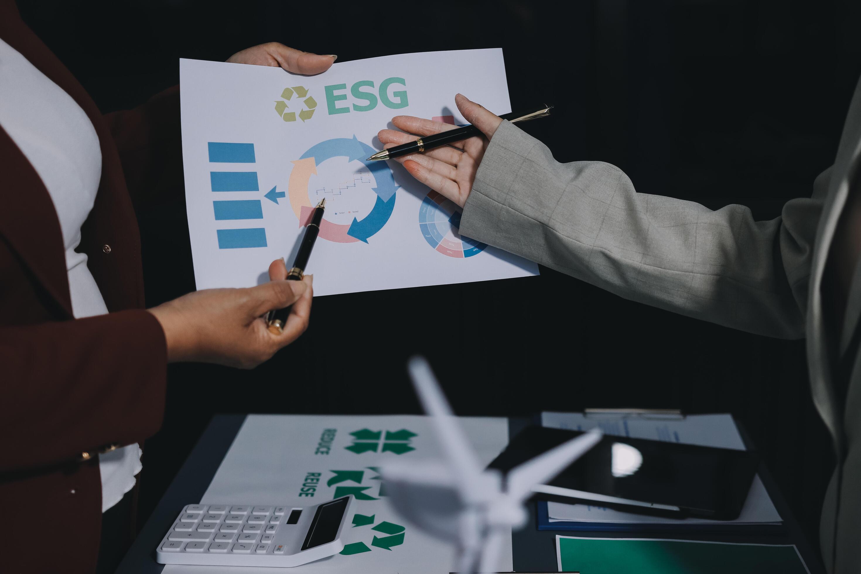 Two people holding a paper with the esg logo on it 56025582 Stock Photo at Vecteezy