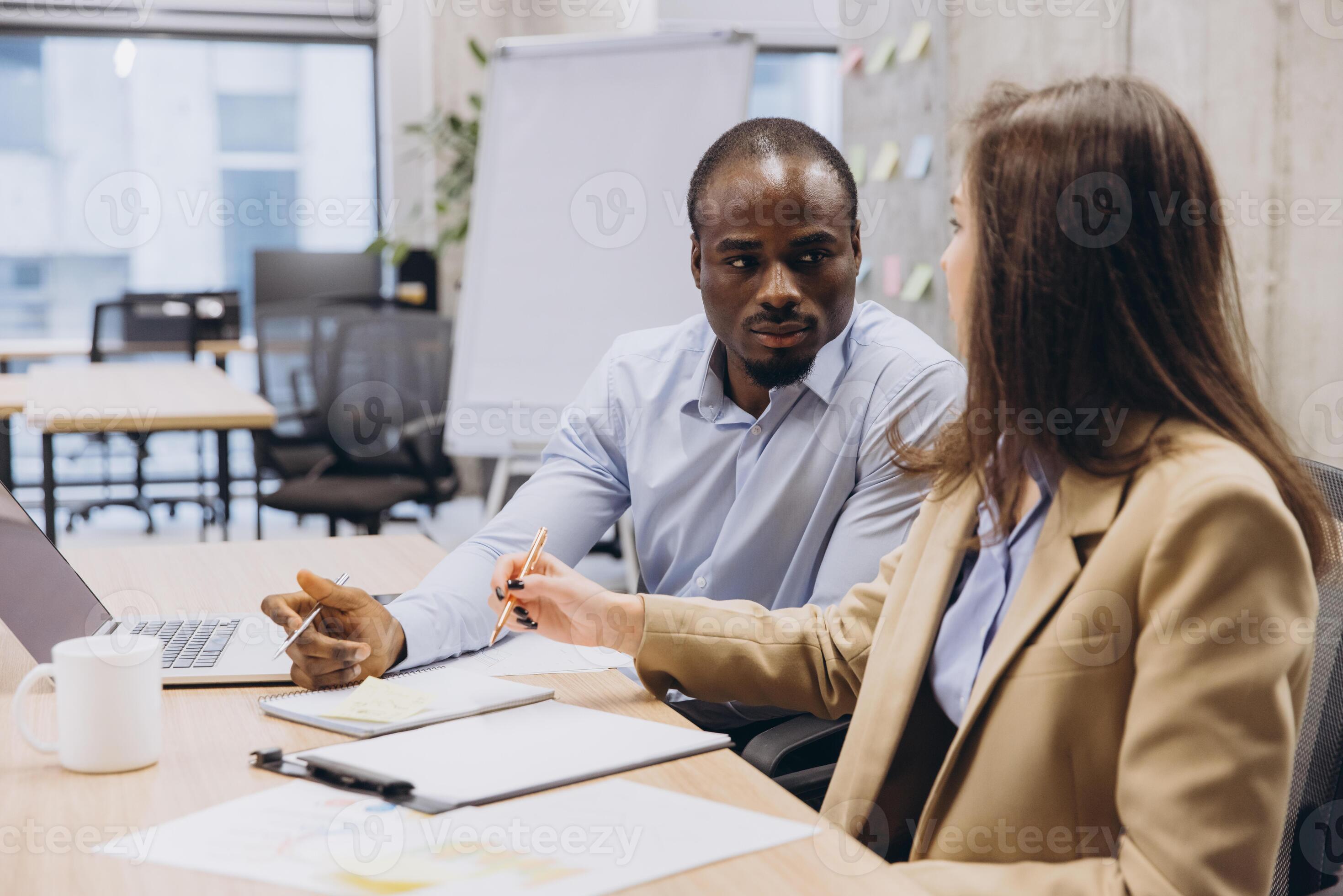Businesspeople Collaborating Discussing Project Details While Working