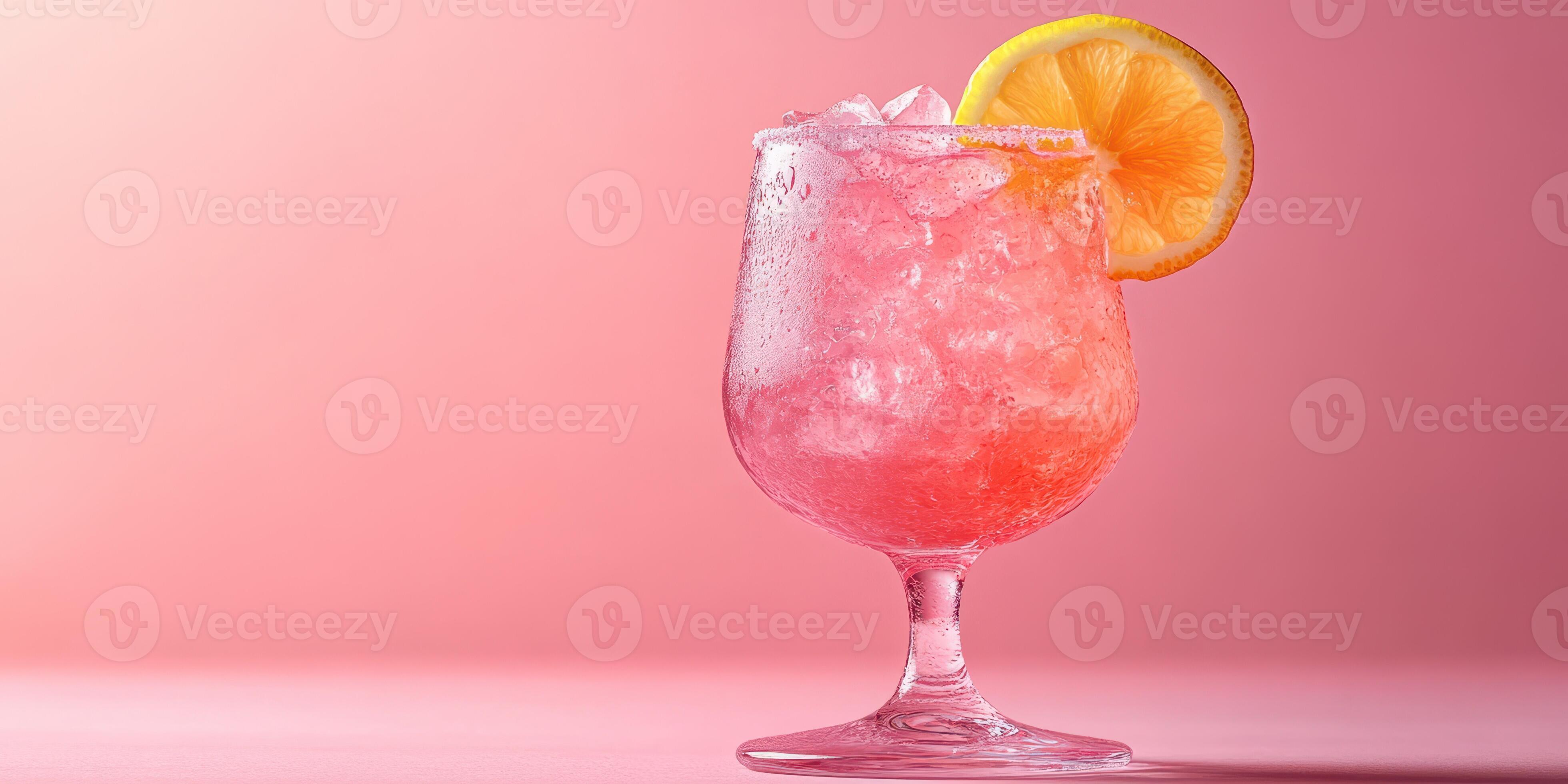 Refreshing pink drink served in a clear glass with ice and a lemon slice against a soft pink ...