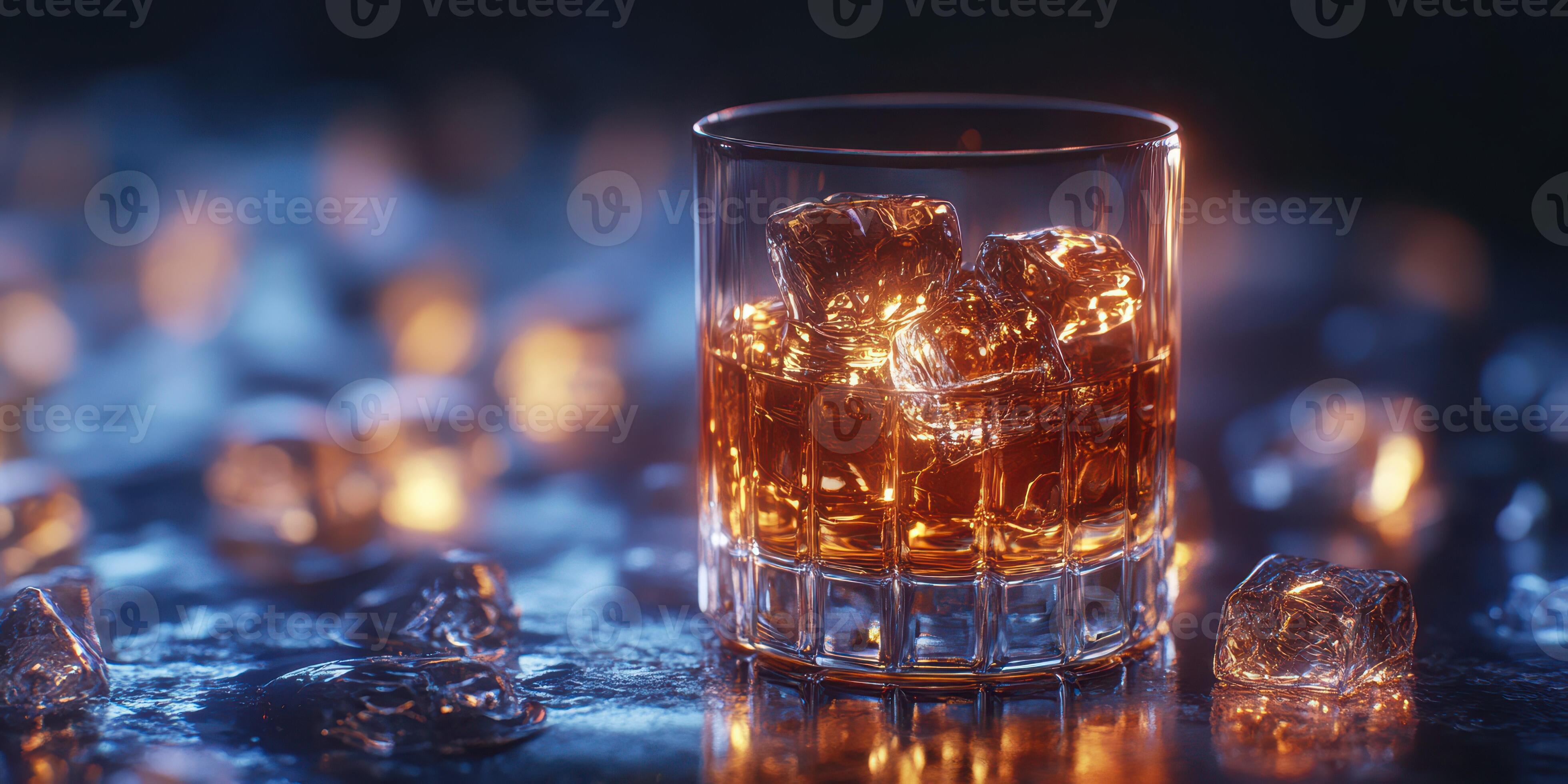 Glass of whiskey with ice cubes illuminated in a dimly lit setting on a reflective surface ...