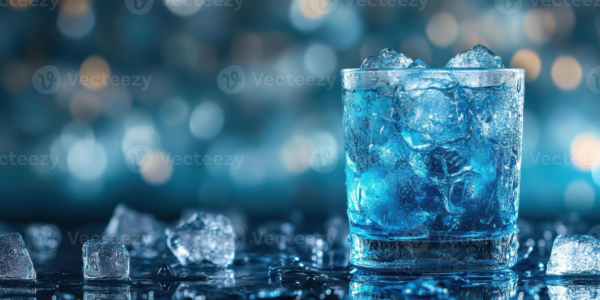 Refreshing blue cocktail surrounded by ice on a dark surface with shimmering background at a ...