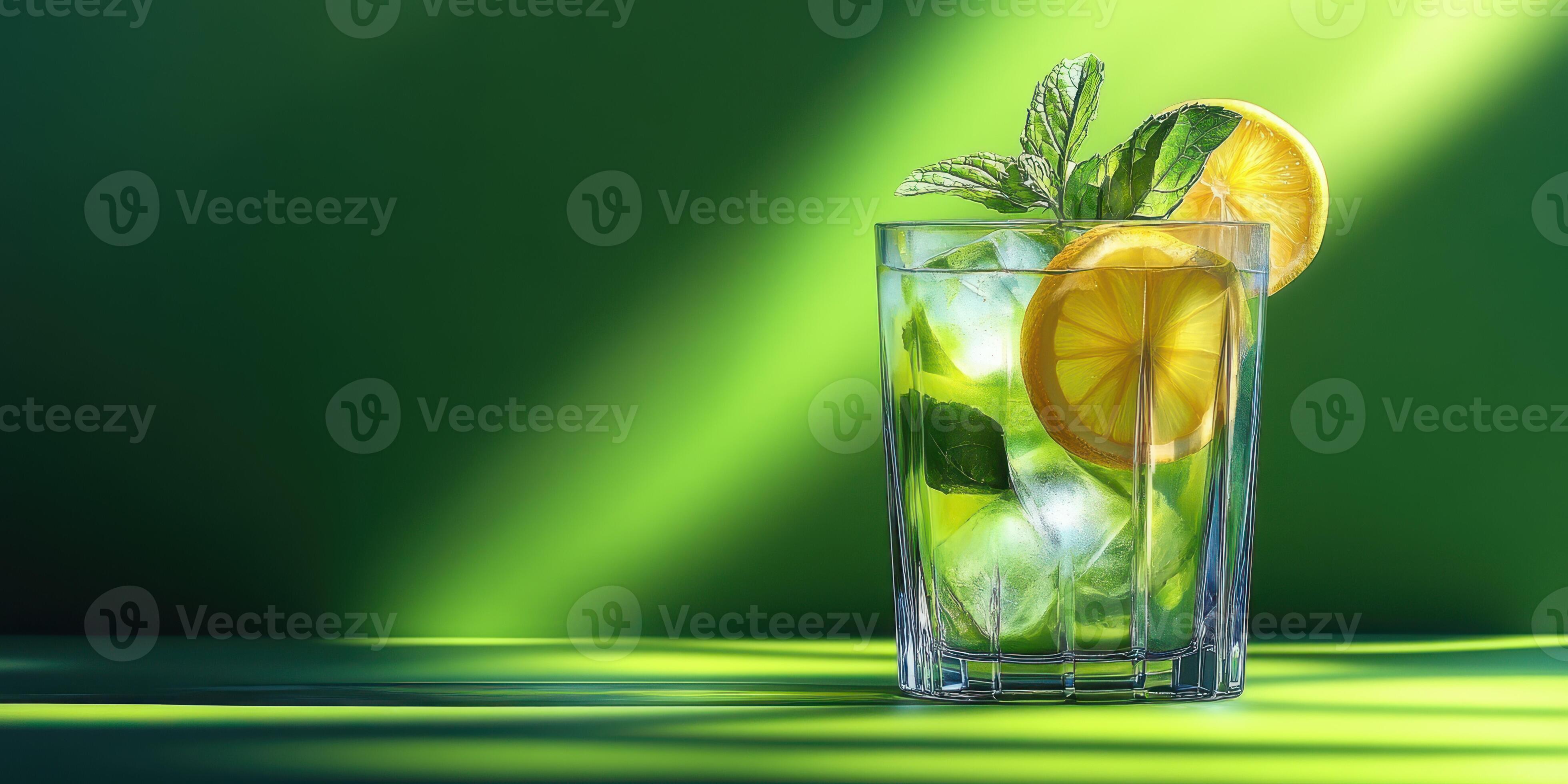 Refreshing cocktail with mint and lemon garnishes sits on green background during bright daytime ...