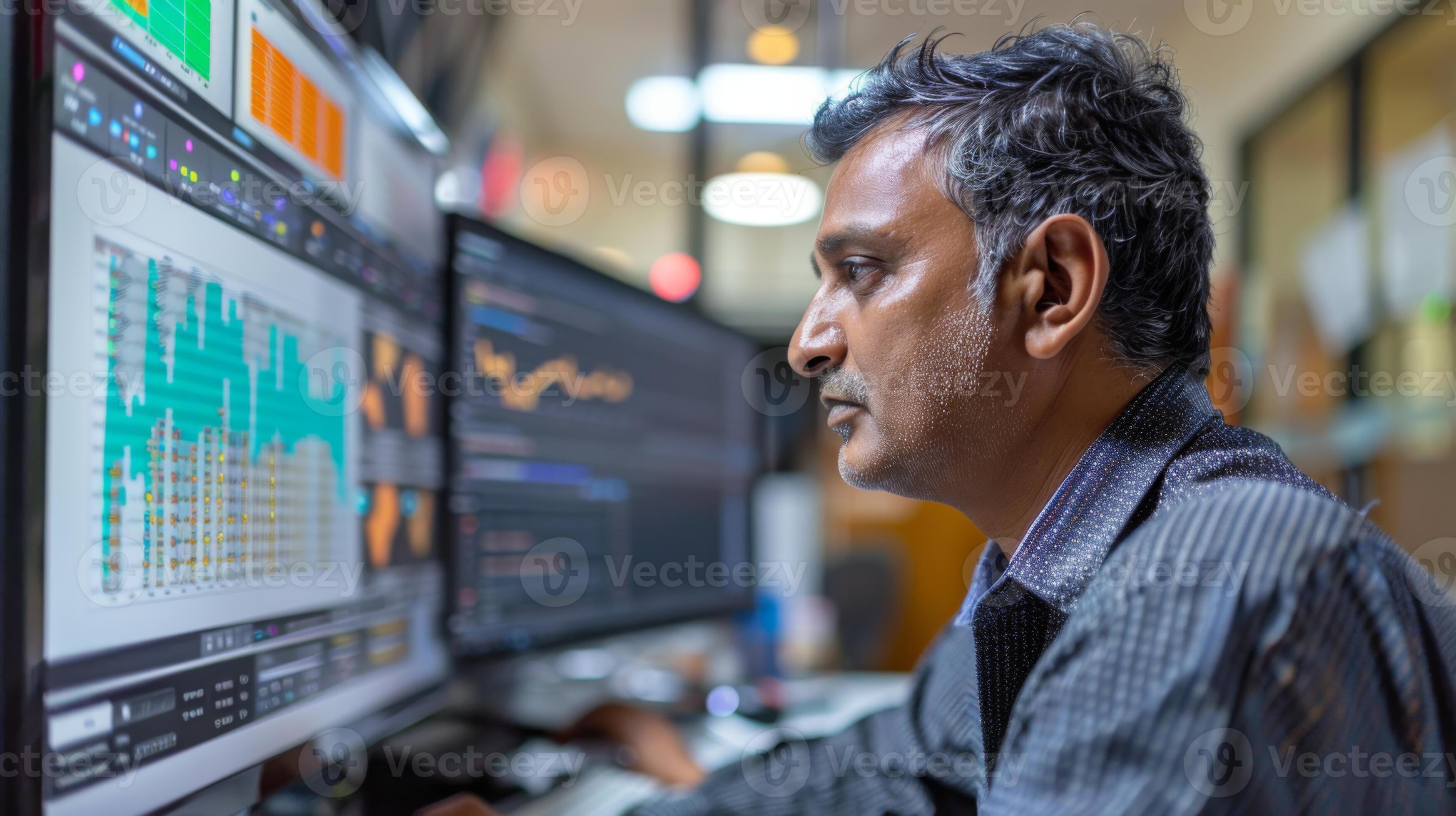 Focused individual reviews complex data visualizations on two computer ...