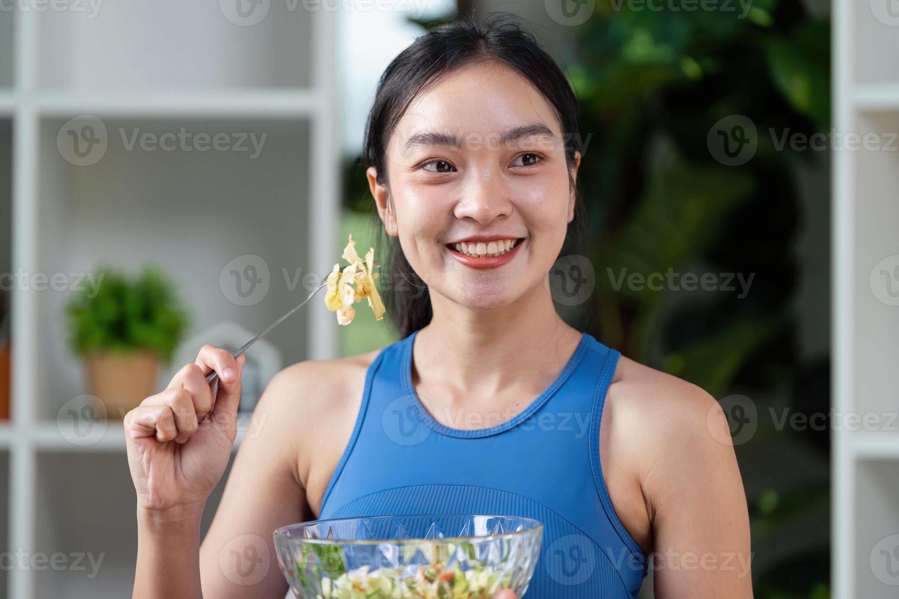 Healthy woman enjoying a fresh salad, smiling and holding a fork, promoting wellness and ...