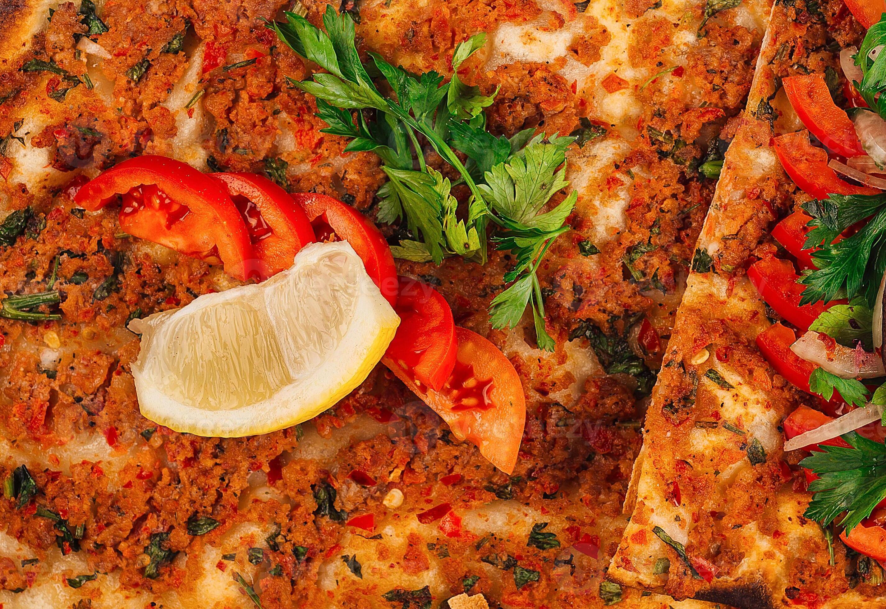 Turkish traditional food lahmacun with lemon and tomatoes being served ...