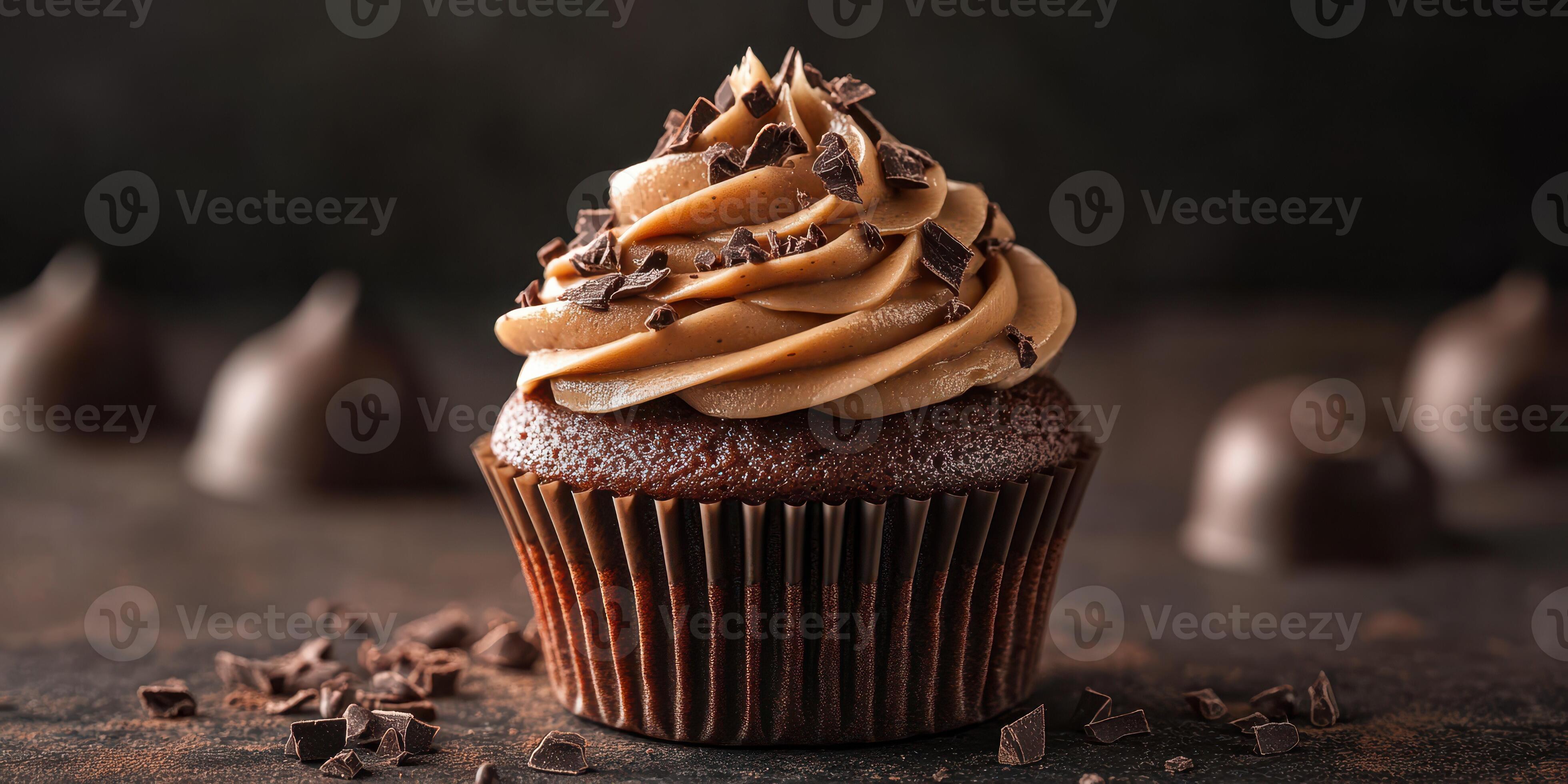 Delicious chocolate cupcake topped with creamy frosting and chocolate shavings in a dark setting ...