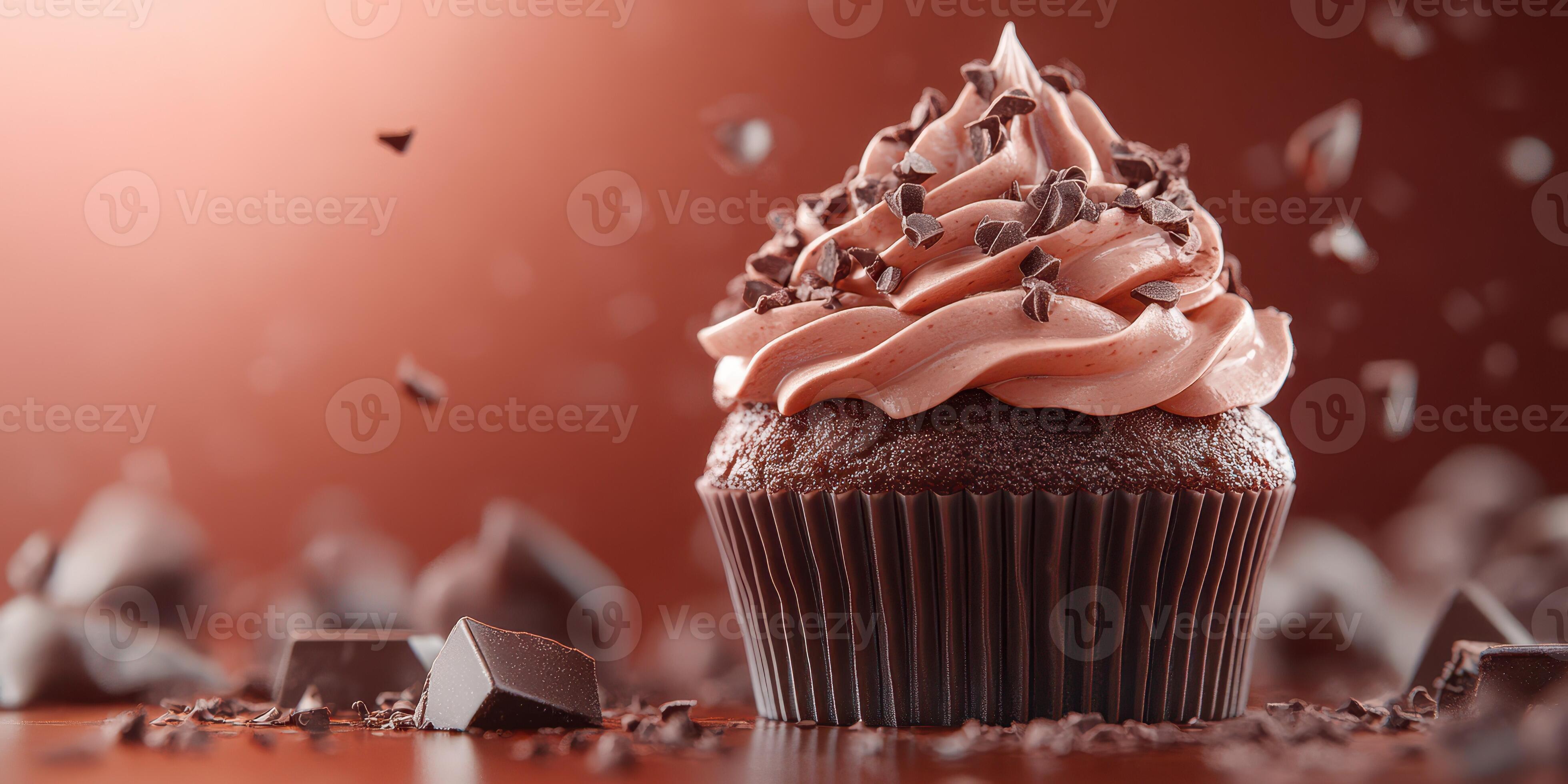 Delicious chocolate cupcake topped with swirls of frosting and chocolate shavings on a warm ...