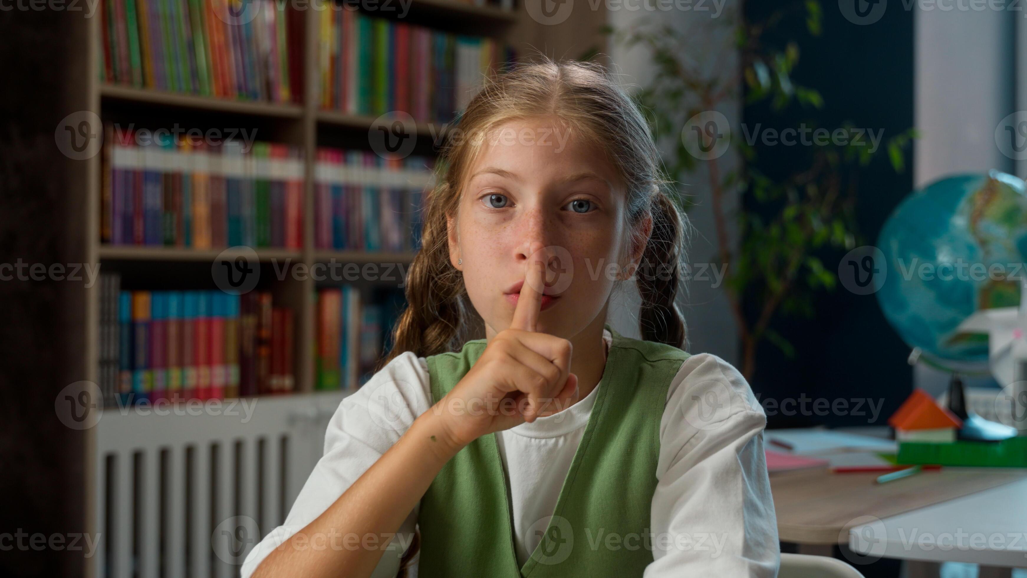 Smiling Caucasian little girl playful schoolgirl child school kid pupil learner student point ...