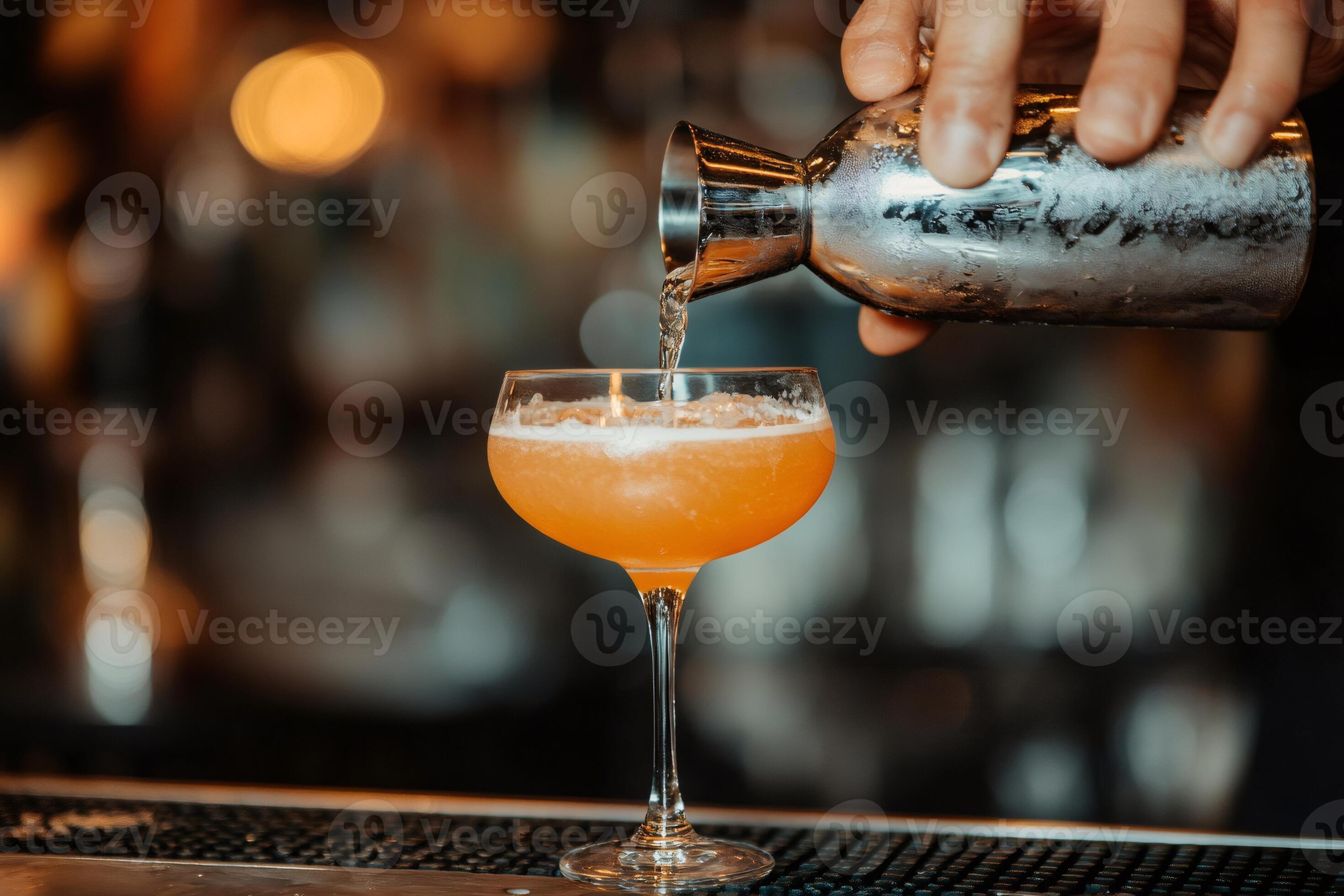 Bartender pouring alcoholic beverage into coupe glass in bar 57159614 Stock Photo at Vecteezy