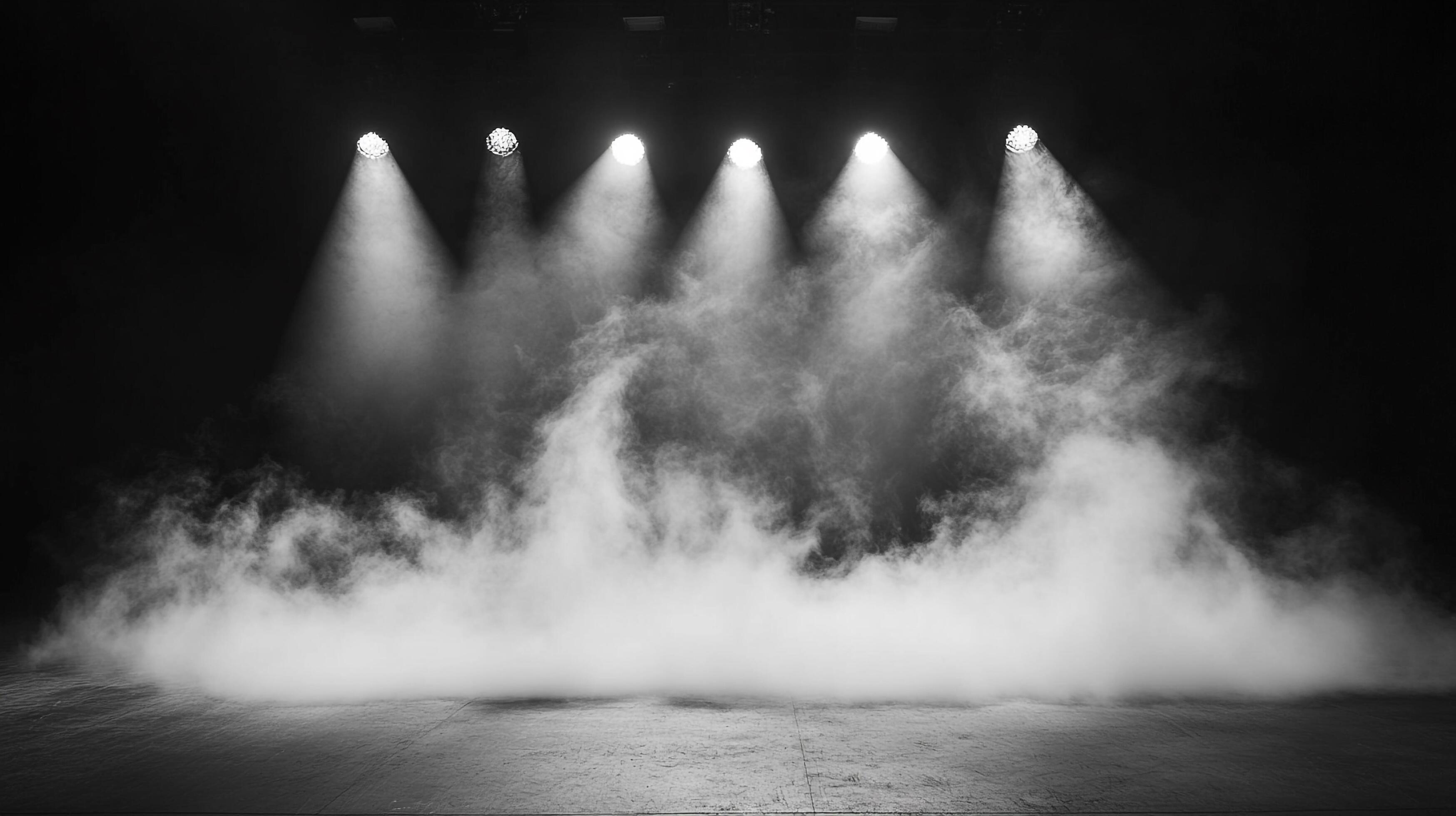 A dramatic stage illuminated by bright spotlights piercing through a thick layer of fog ...