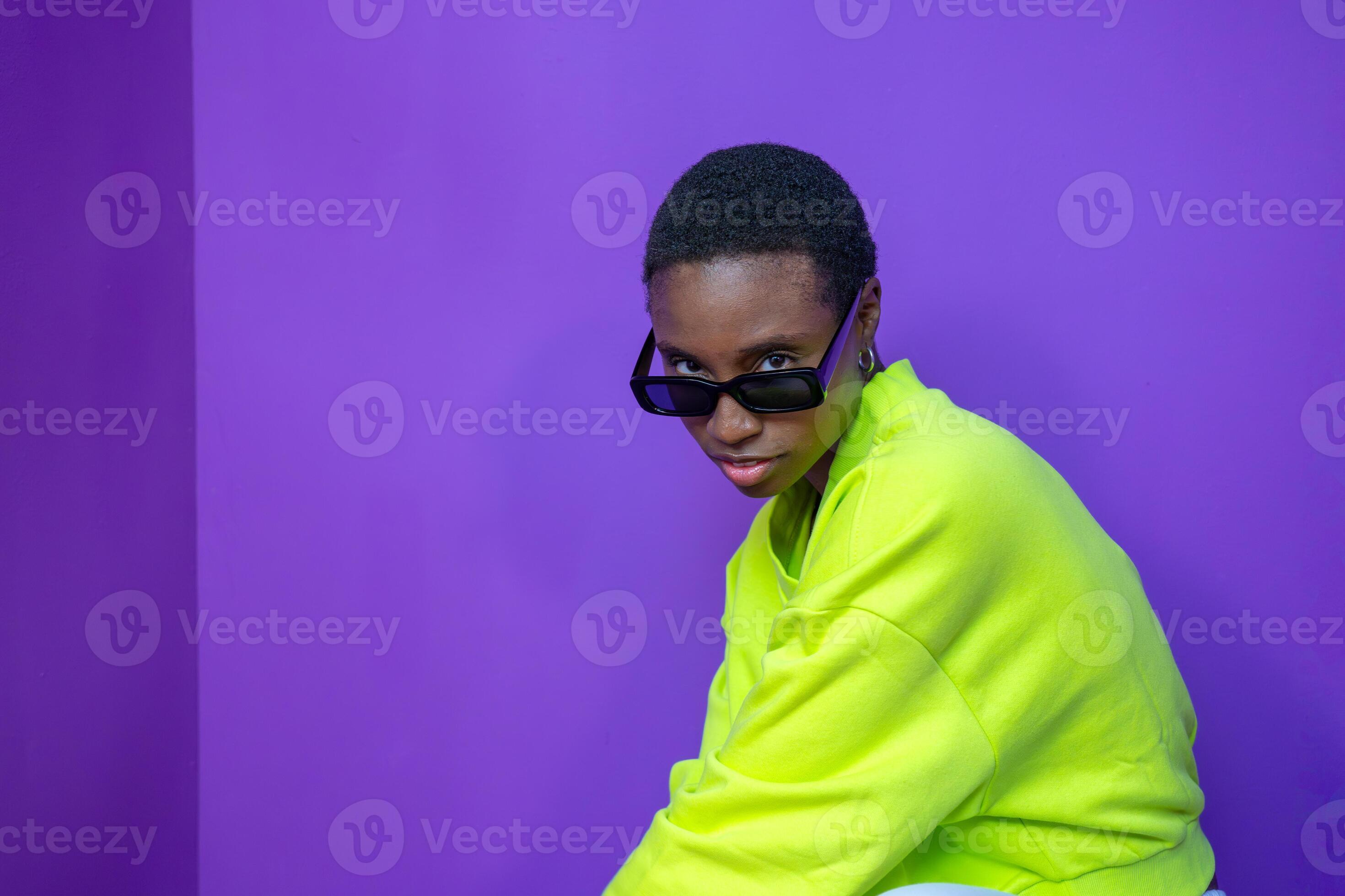 A Stylish Individual Posing in a Neon Sweater Standing Out Against a Purple Background 57283177 ...