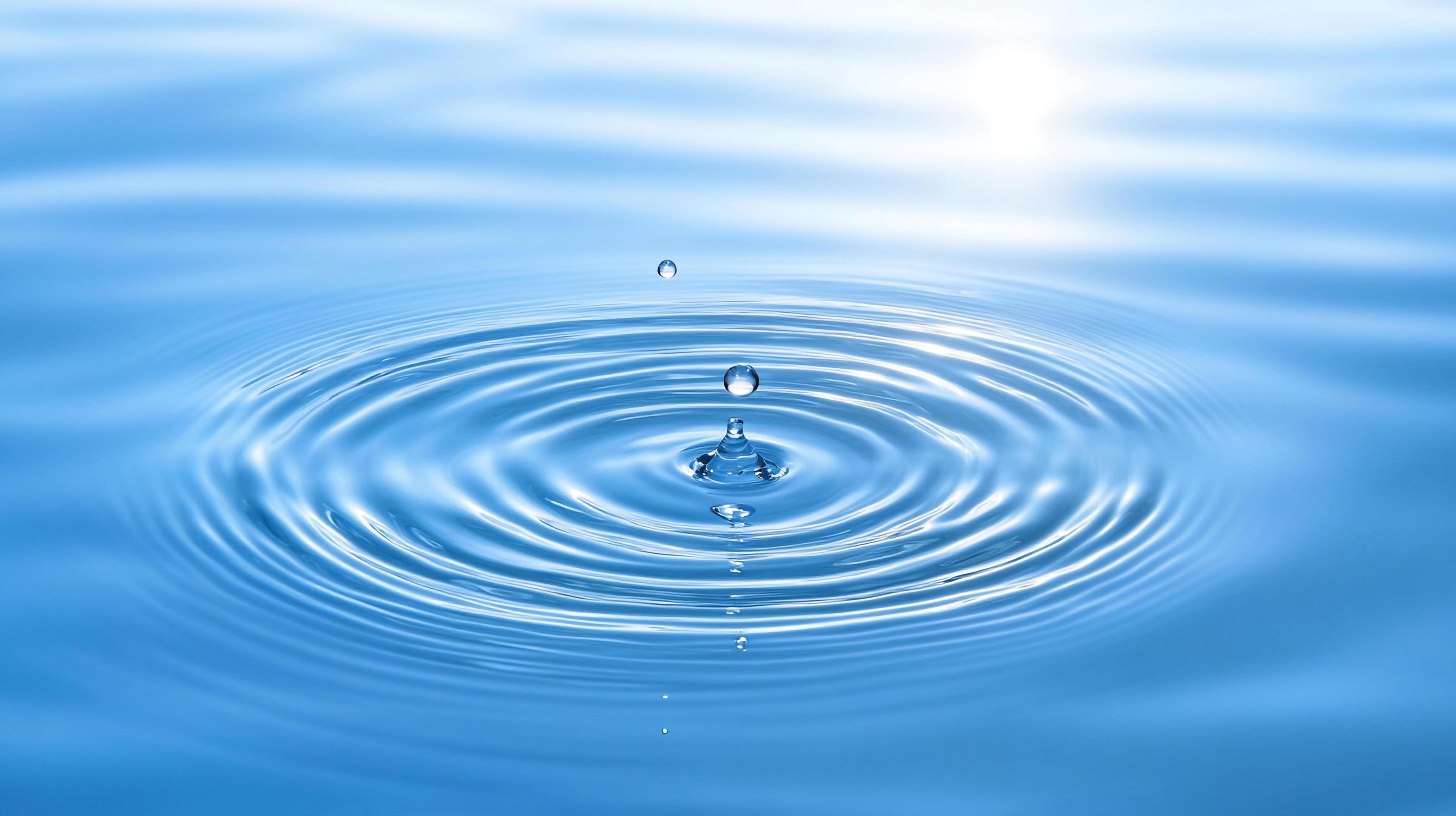 Captivating water droplet creating concentric ripples. Peaceful blue water surface, creating ...