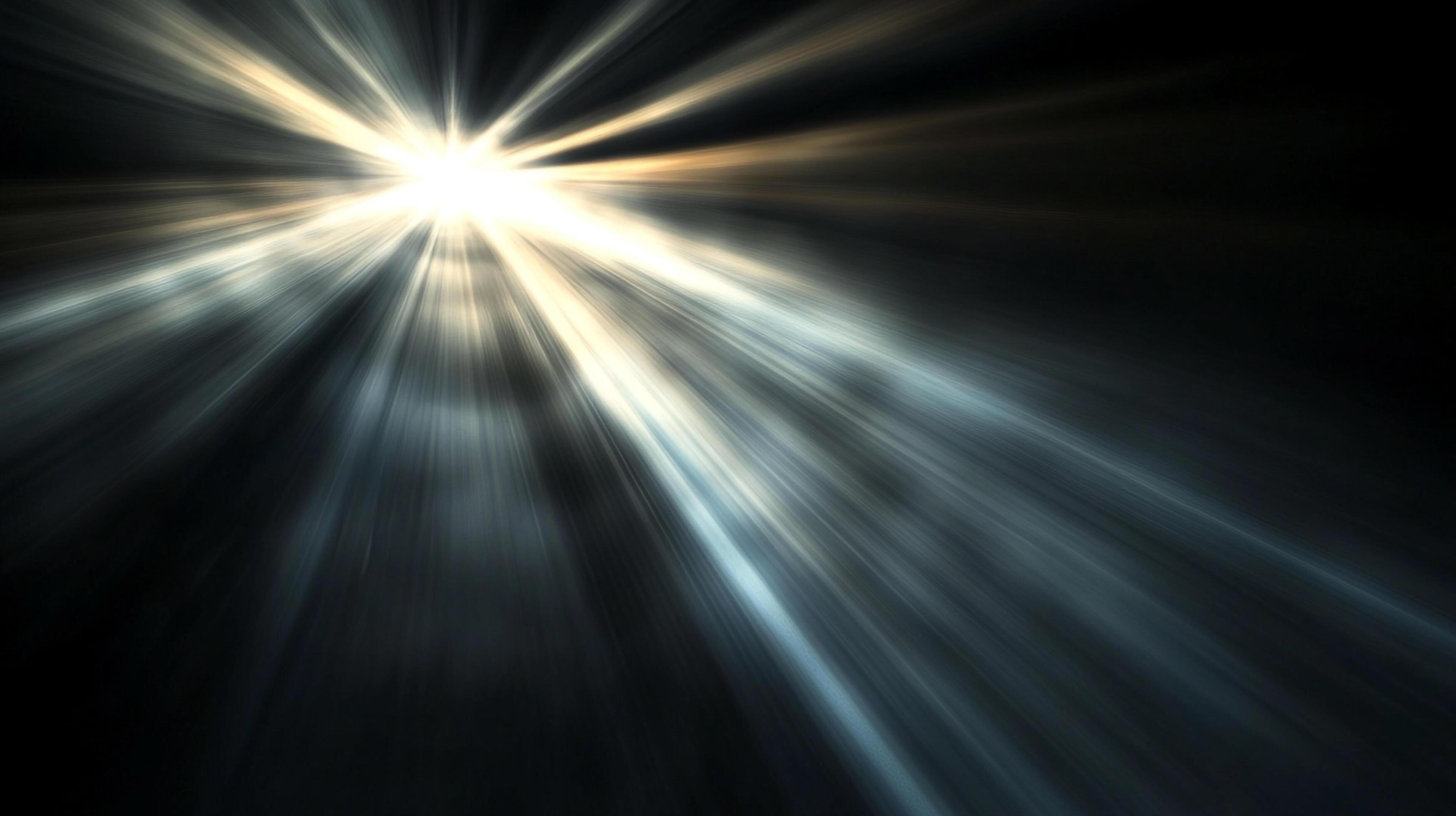 Rays of light emanating from a bright center, casting radiant beams across a dark expanse. The ...