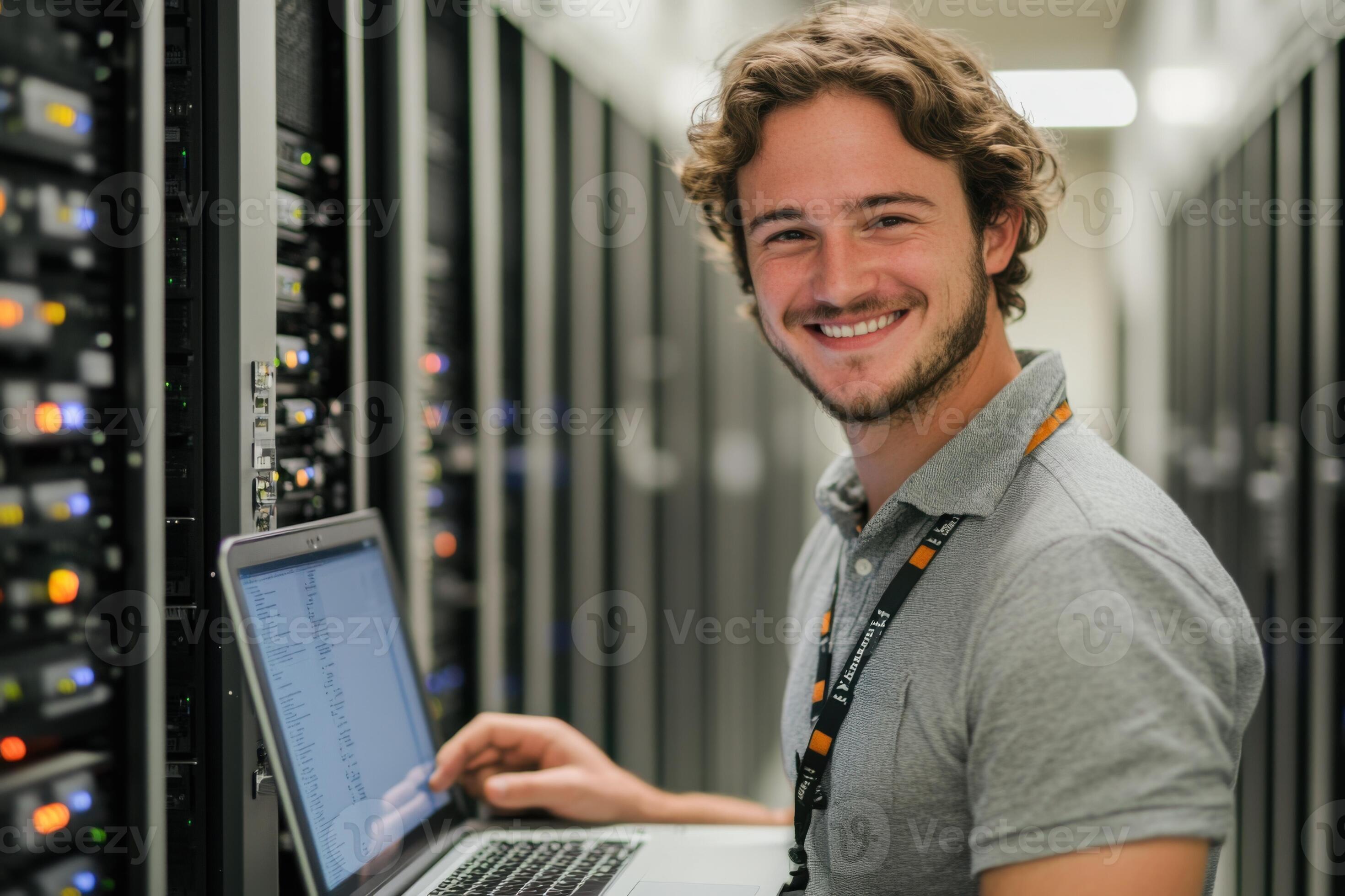 Server room. Man works on laptop computer. Smiling person in data center. Network engineer with ...