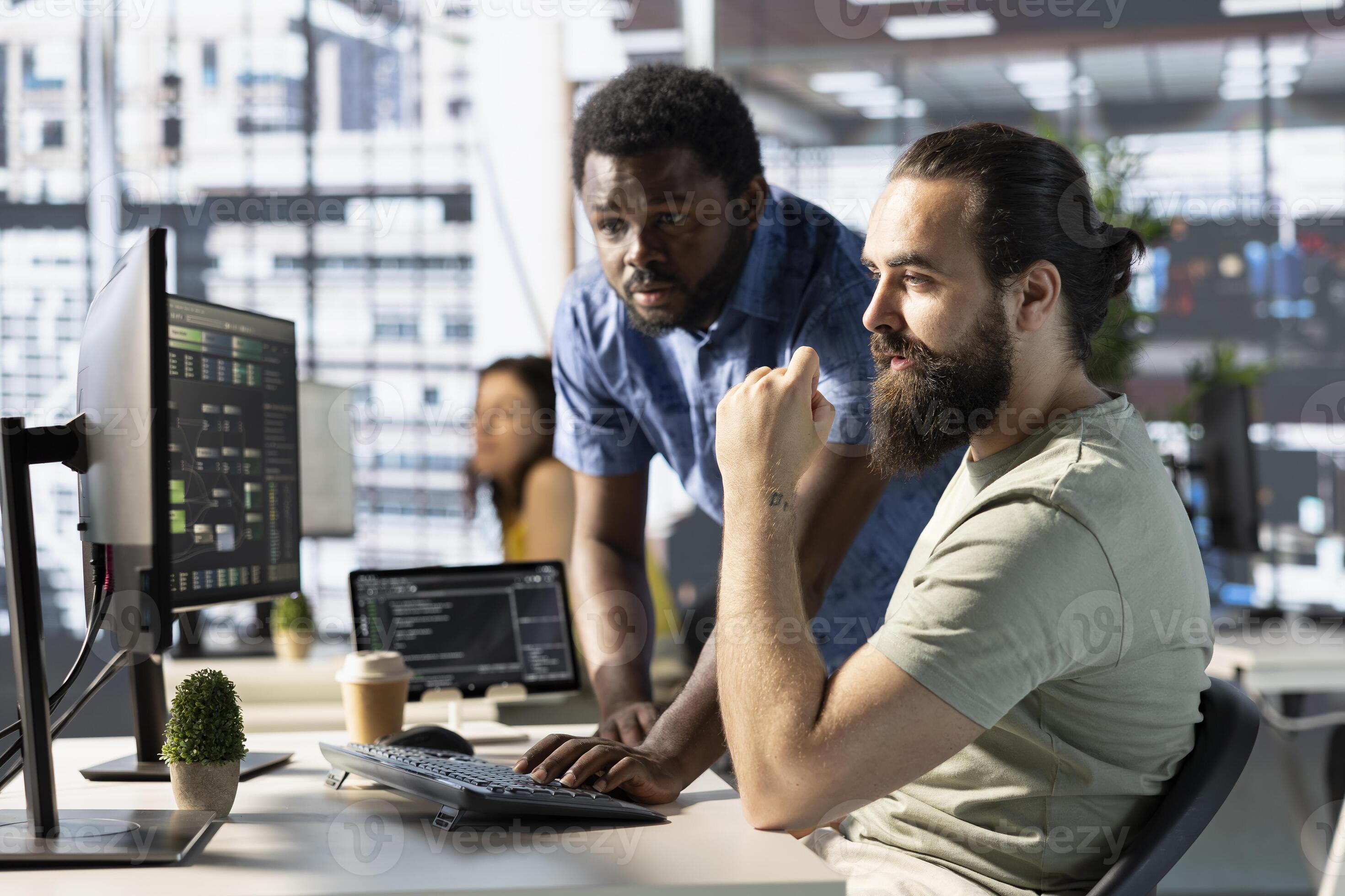 Data engineer and coworker at PC desk developing machine learning algorithms. Programmer and ...