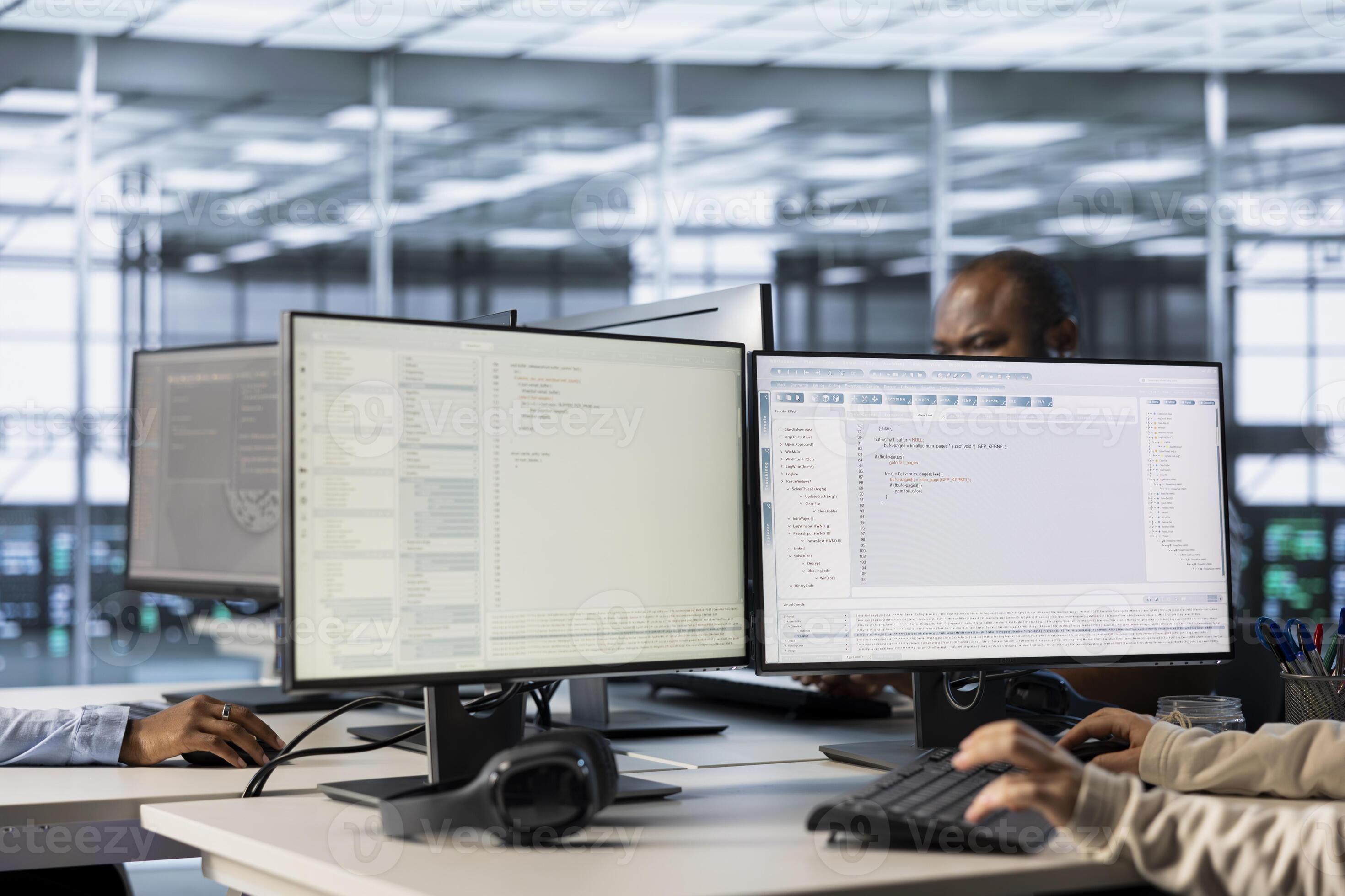Lines of code running on computer screens in data center, used by employees to troubleshoot ...