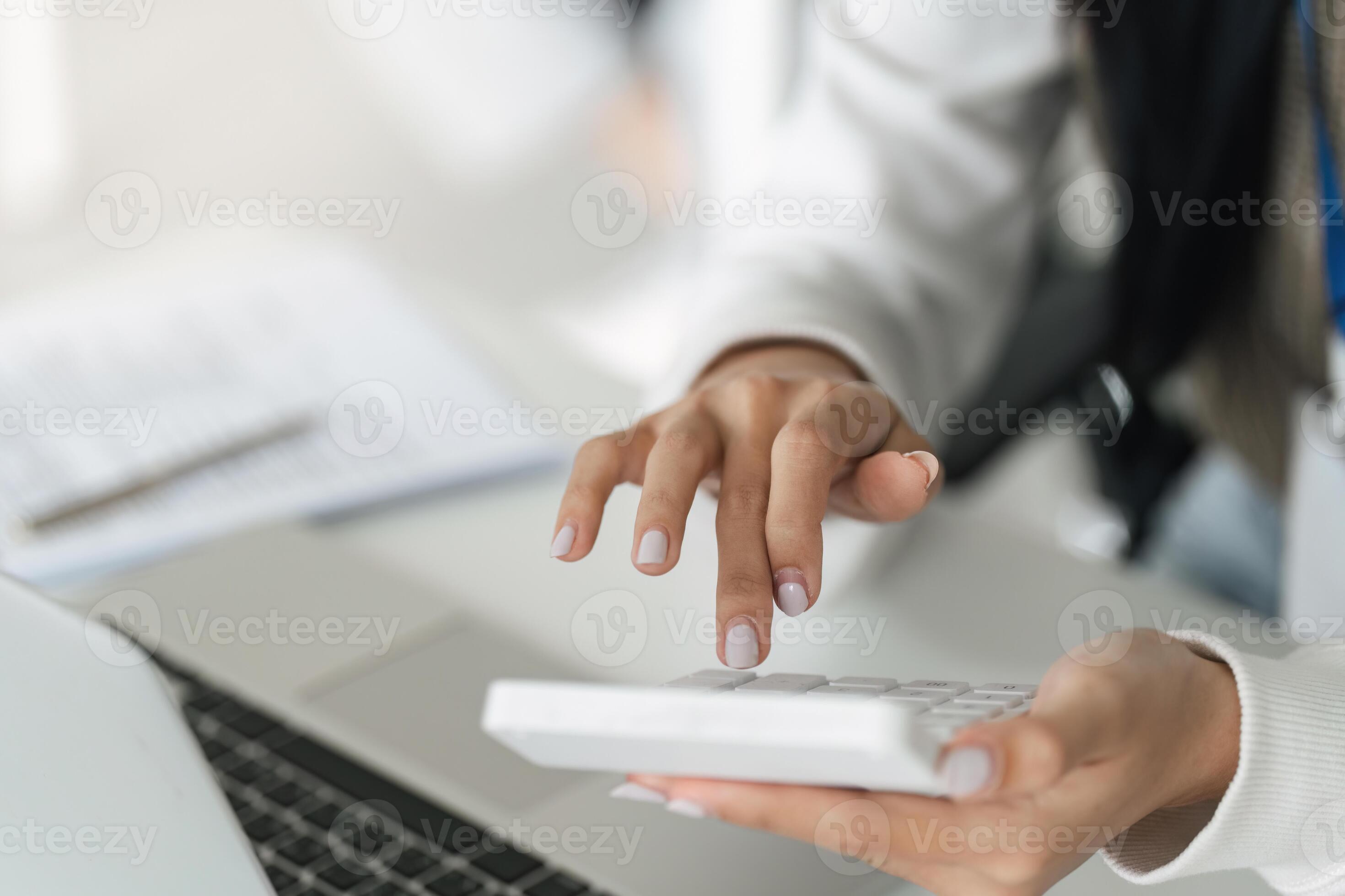 Close-up of hands using a calculator for financial calculations, emphasizing accuracy and ...