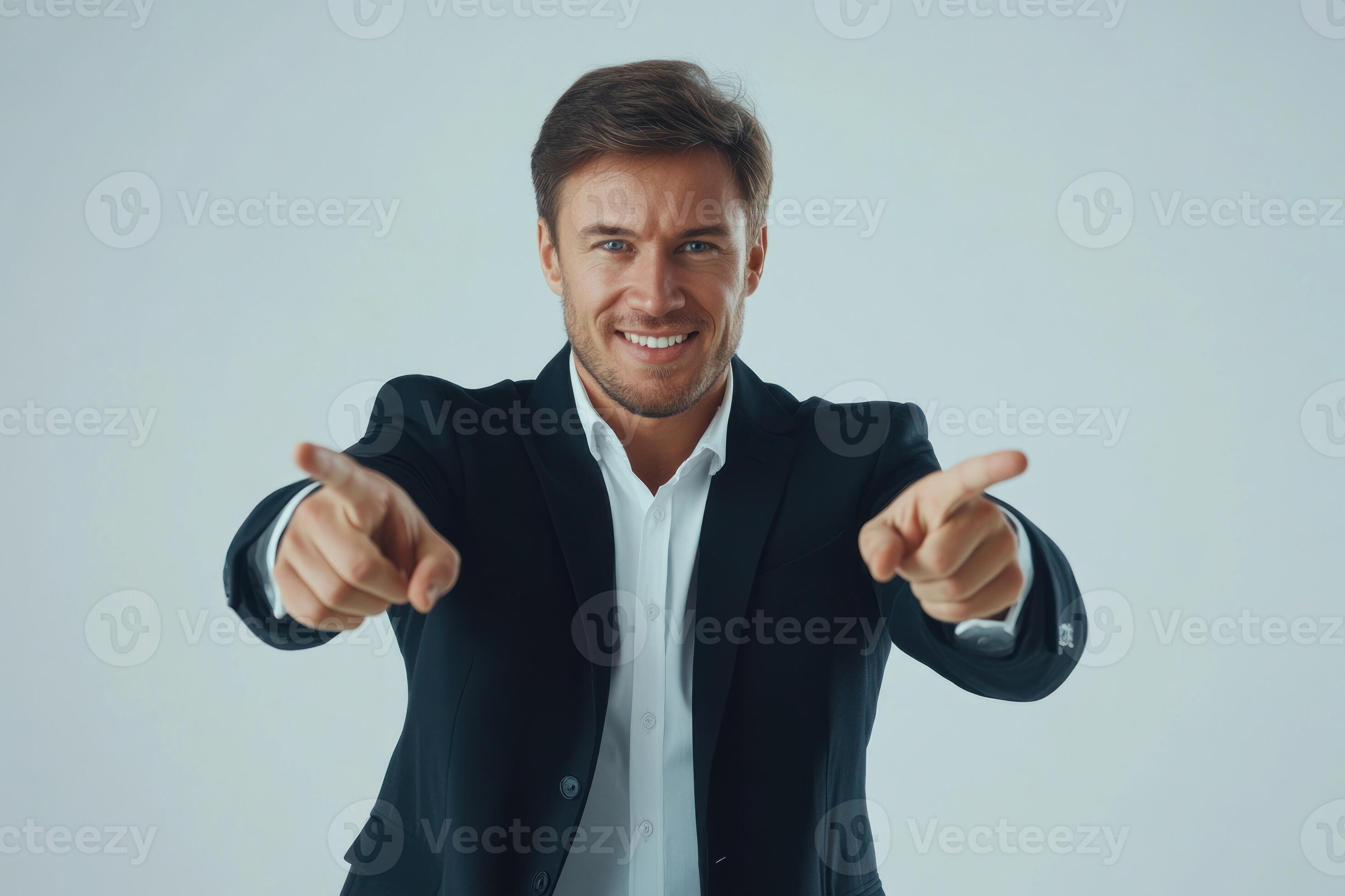 Confident man pointing and smiling in professional attire against a ...