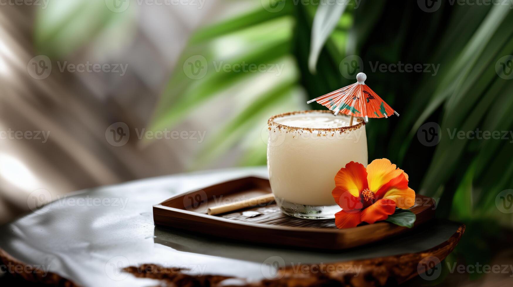 Refreshing tropical cocktail with umbrella and hibiscus flower on wooden tray in lush greenery ...