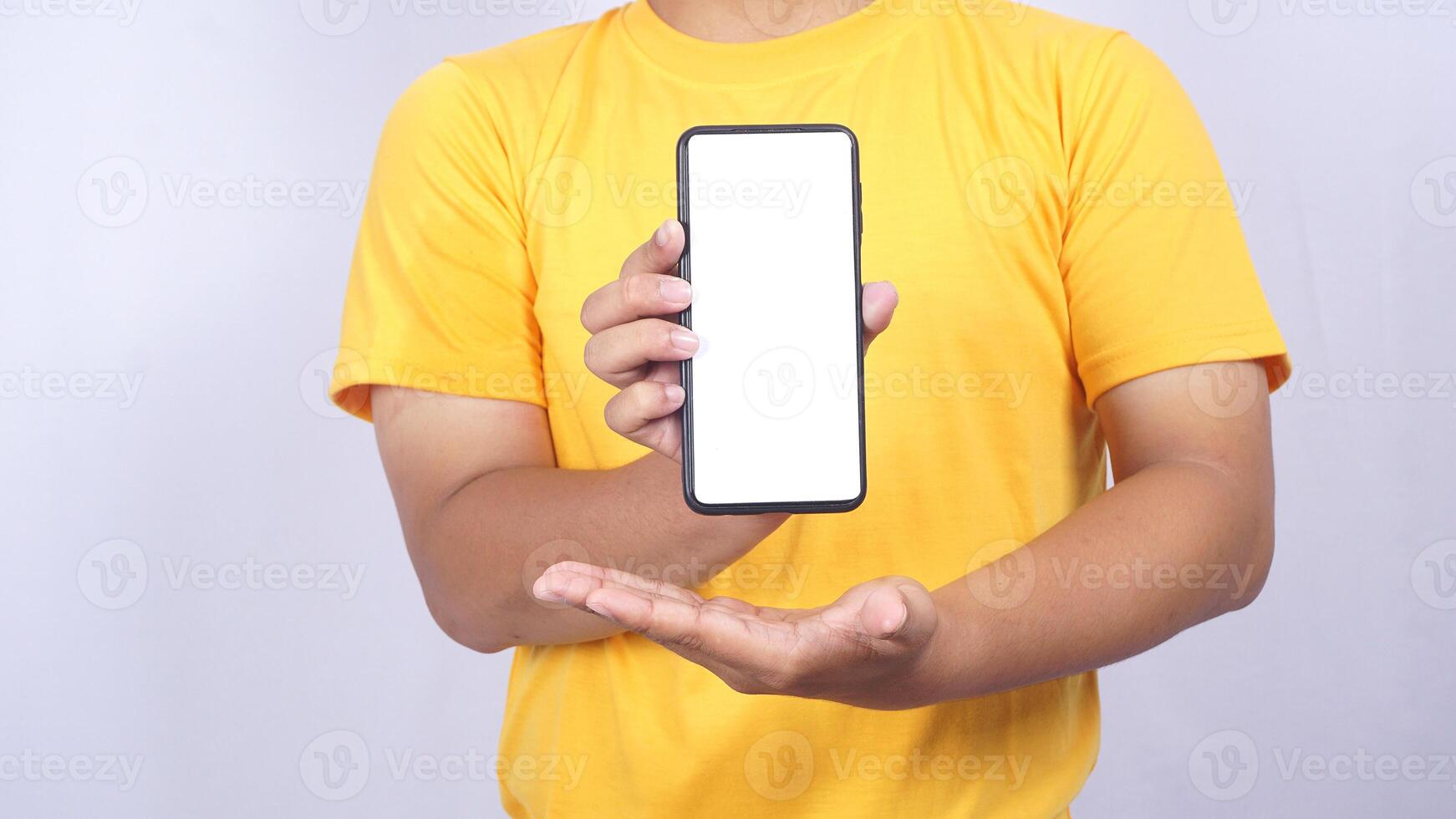 Close up of man presenting mobile phone blank screen mock up isolated on white background ...