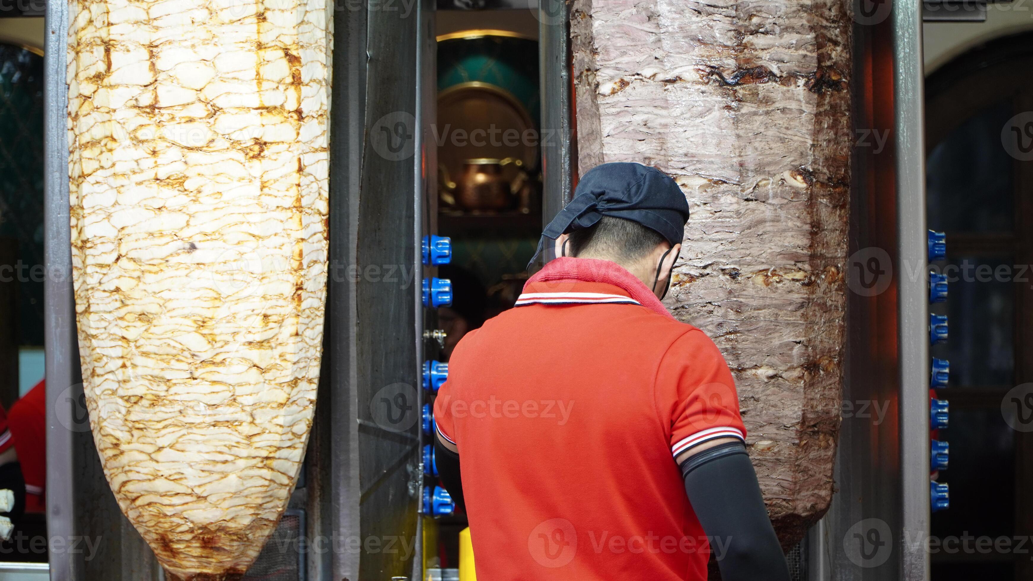 Shawarma meat being cut before making traditional Turkish Doner Kebab. Chef cutting the kebab ...