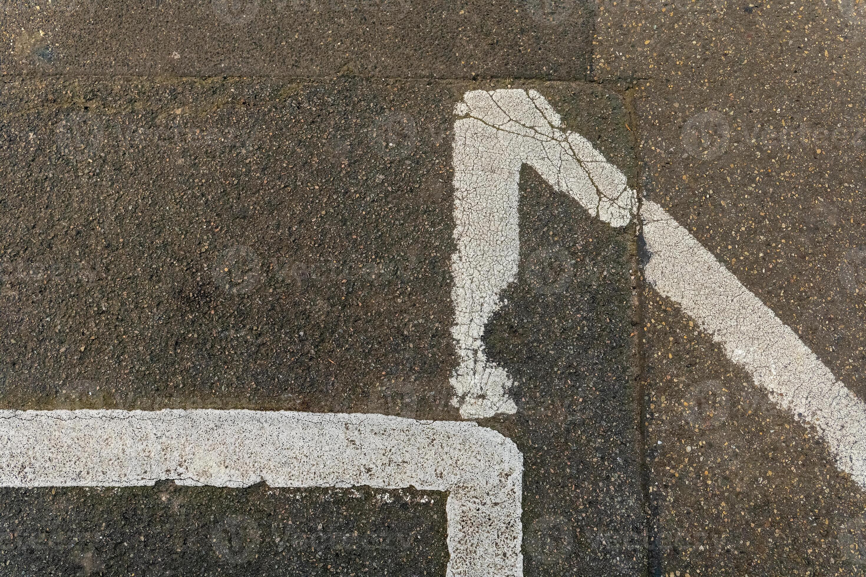 White paint marking on pavement forming an angular design in an urban environment during ...