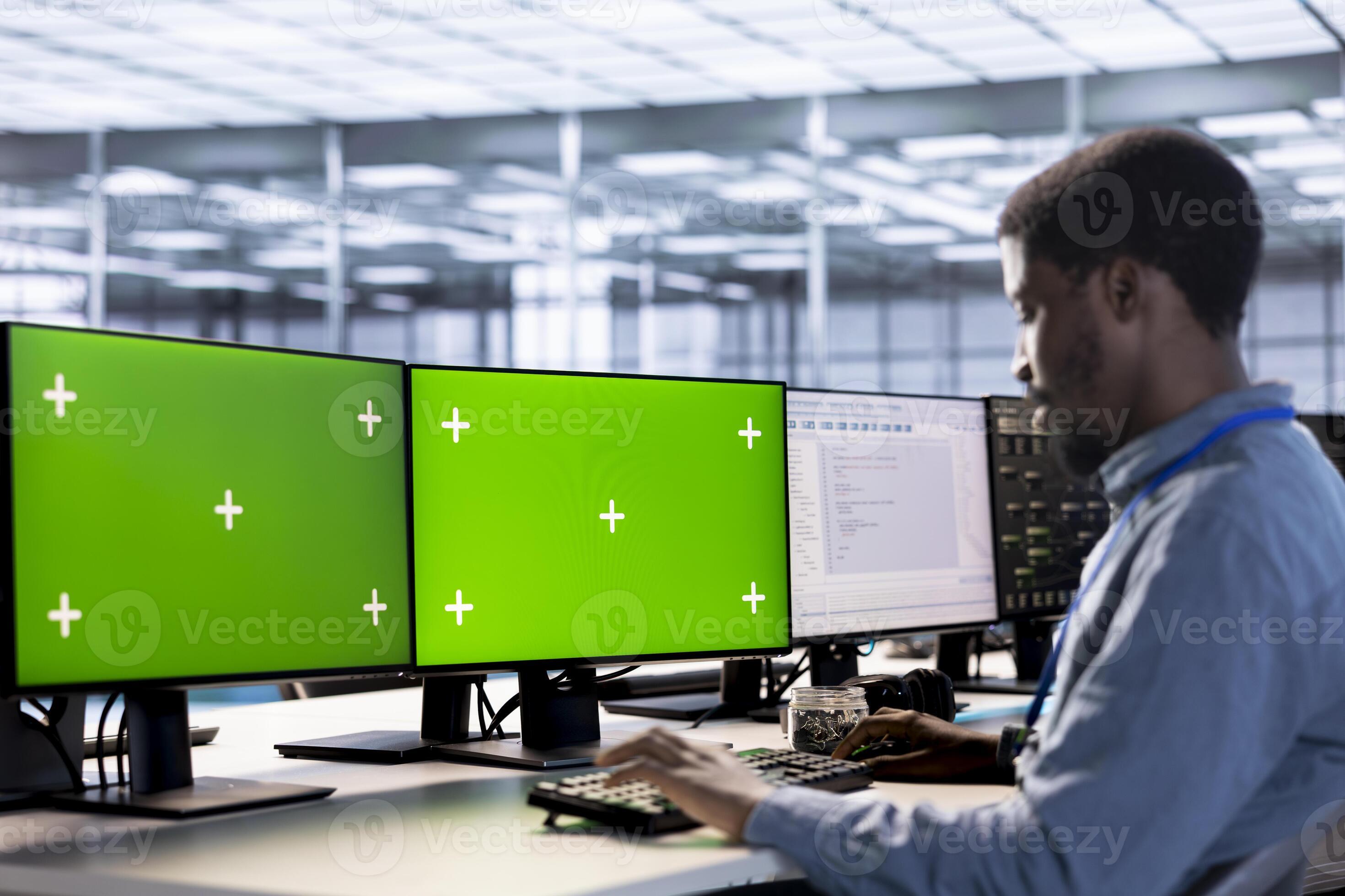 Engineer in server hub ensuring data remains shielded from potential threats using chroma key PC ...