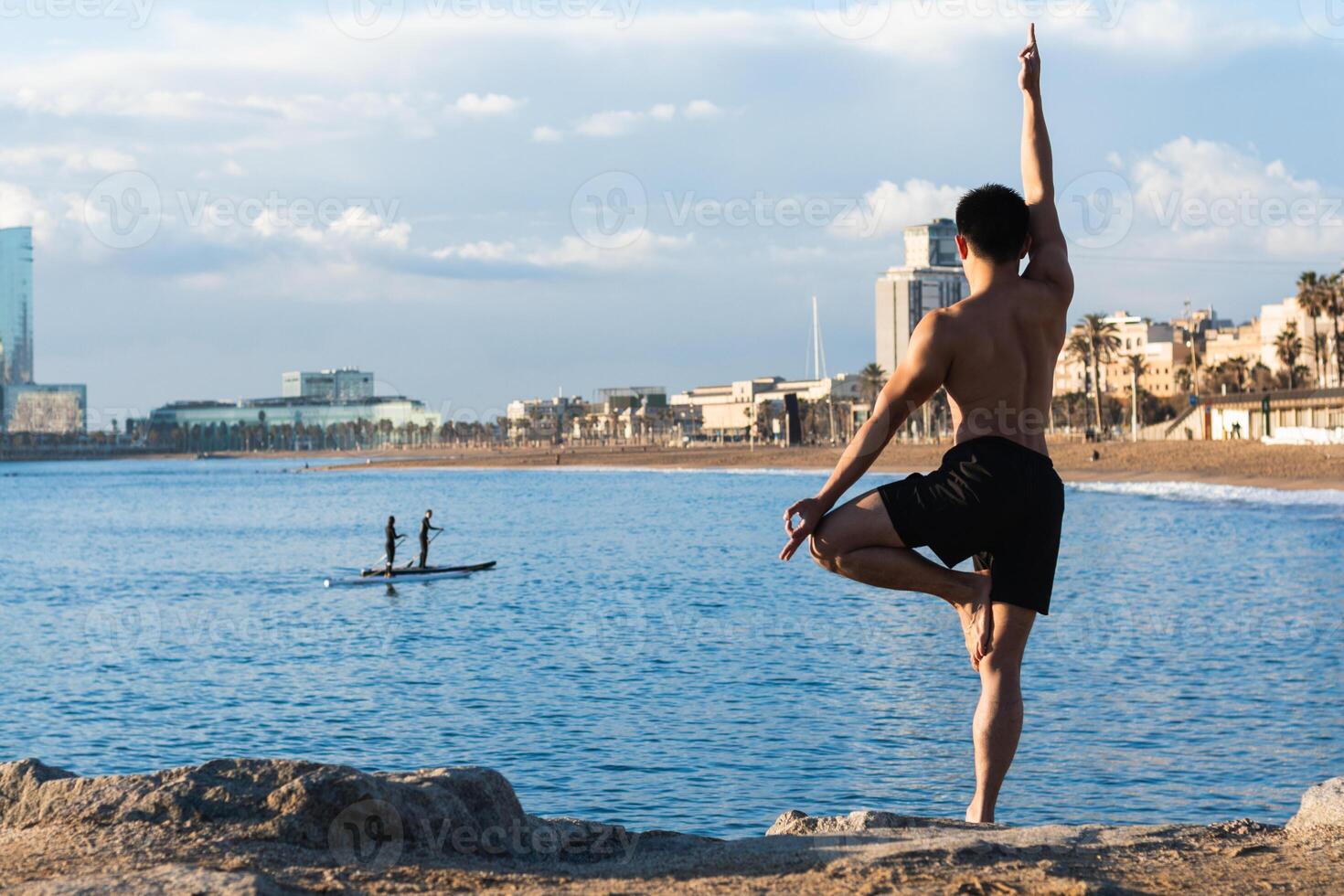 Shirtless man balancing in yoga pose on beach 59238444 Stock Photo at Vecteezy
