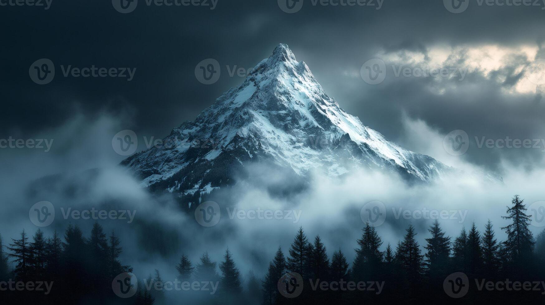 Snowy mountain peak emerging from misty clouds over coniferous forest ...
