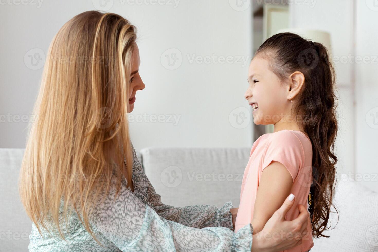 Happy Mother Hugging Little Daughter Sitting On Sofa At Home. Motherhood, Relationship With Kids ...