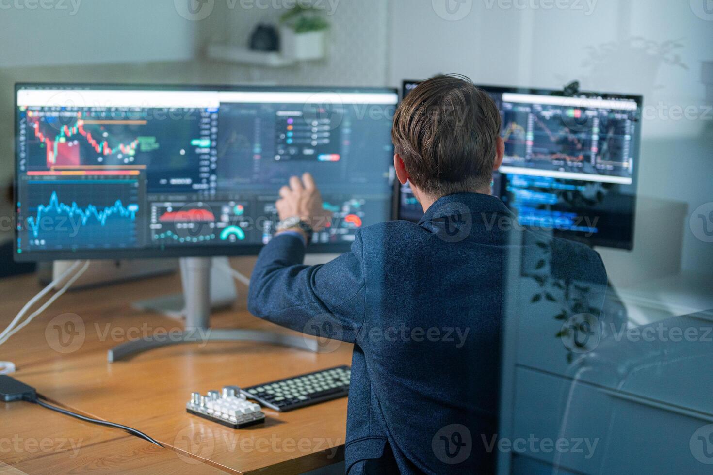 Professional trader analyzing various stock market data on multiple computer screens in a modern ...