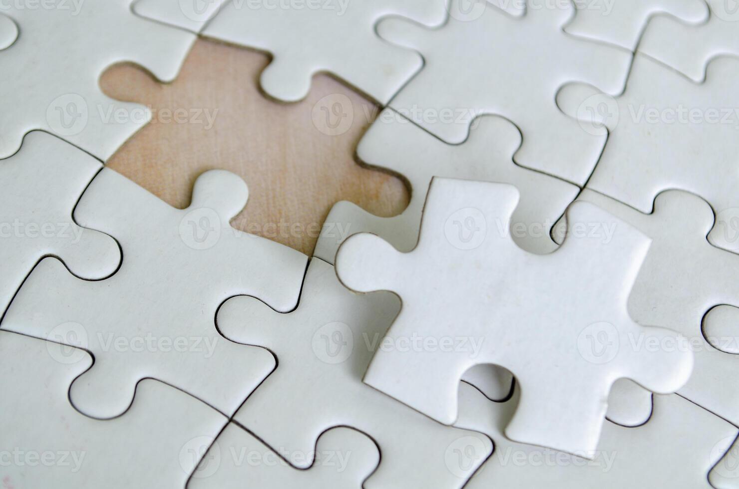 Close up view of interlocking jigsaw puzzle pieces symbolizing problem solving teamwork and ...