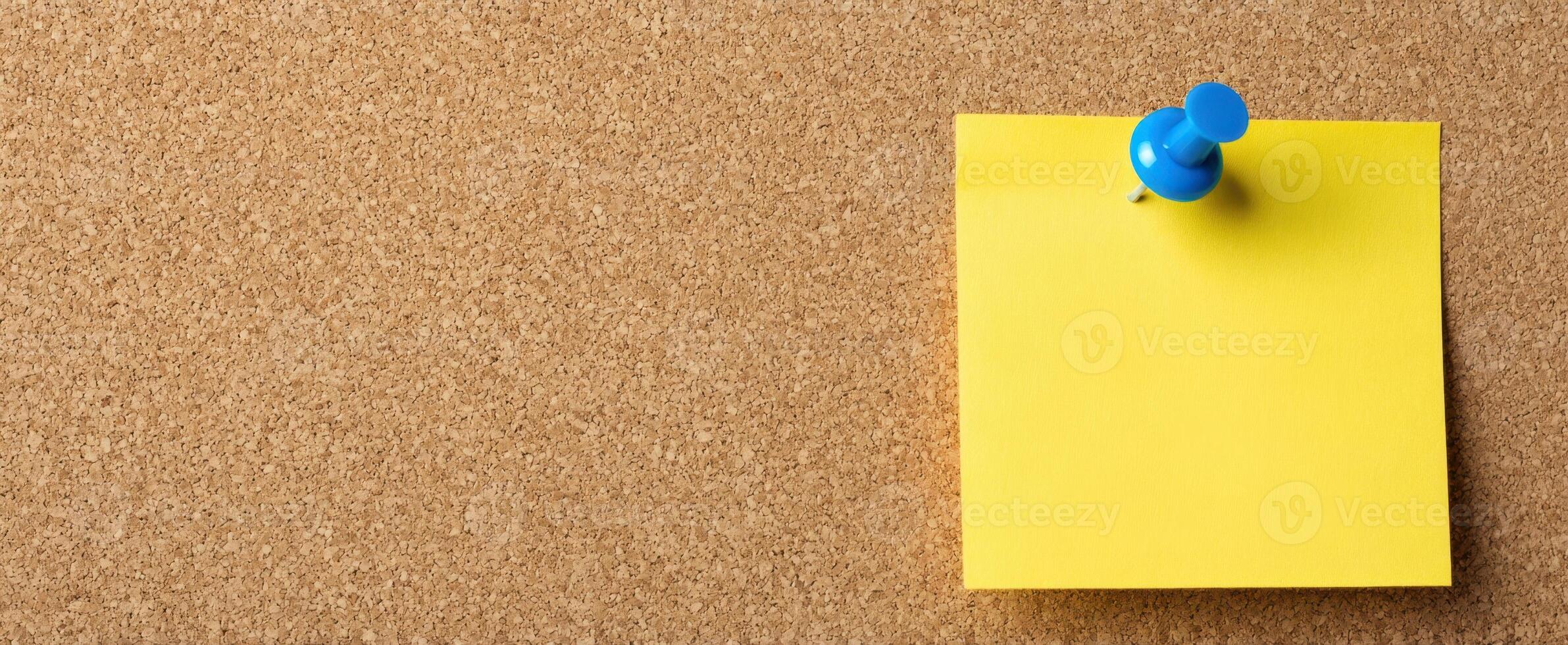 The yellow sticky note pinned on a corkboard background for reminders ...