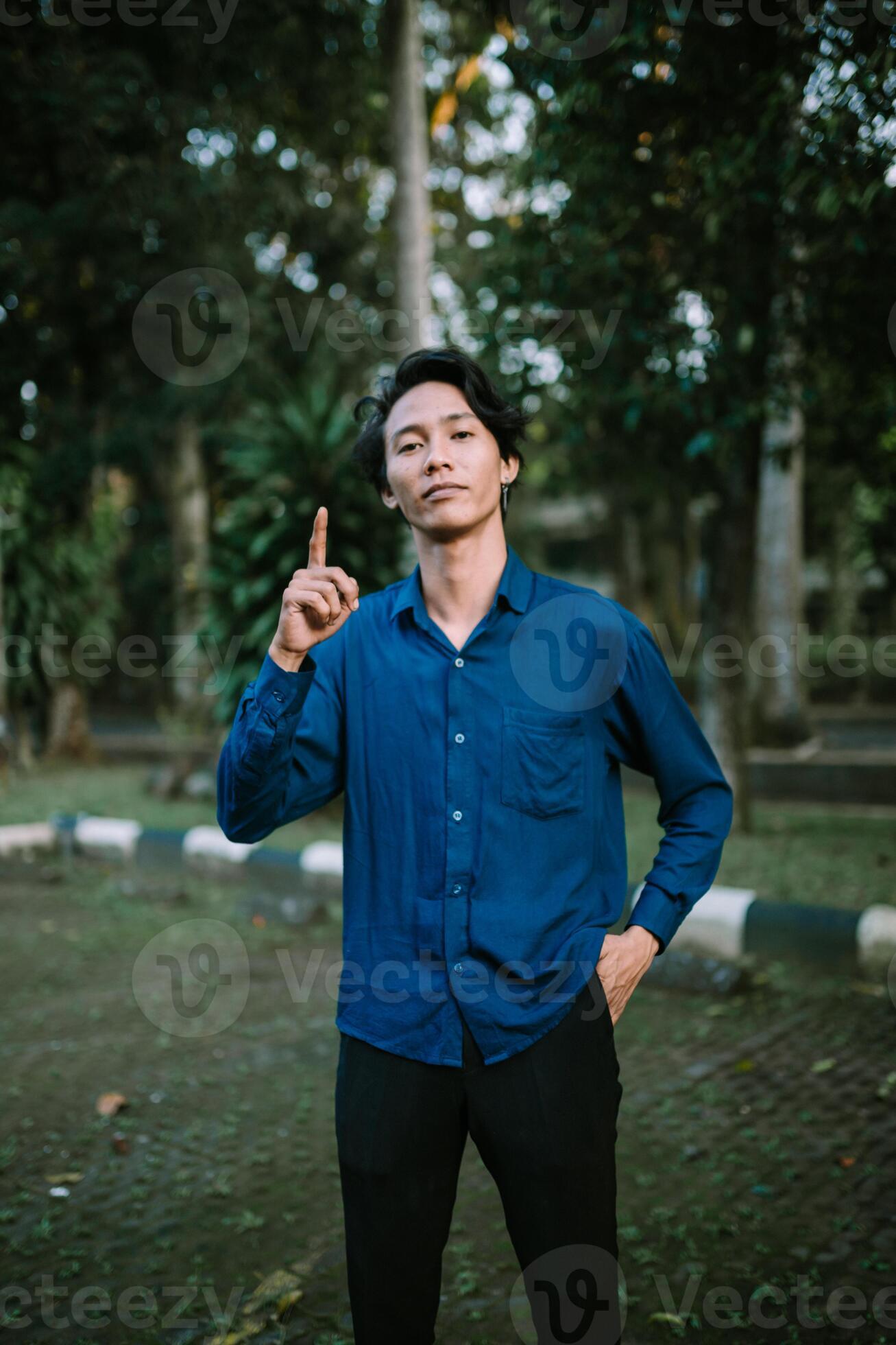 Young man raising finger having eureka moment outdoor in nature 67096178 Stock Photo at Vecteezy