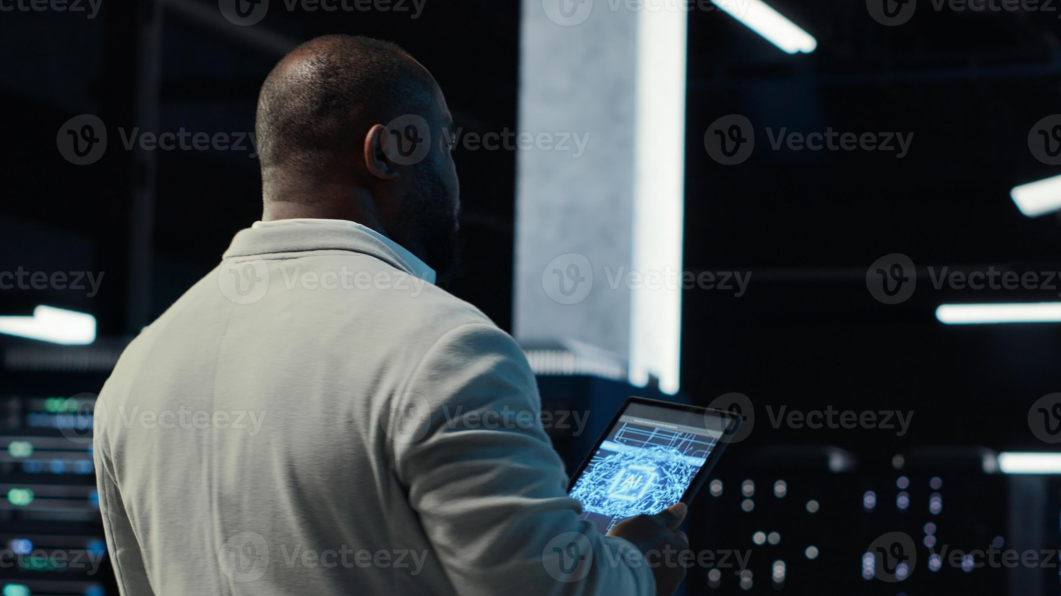 Server room software developer troubleshooting errors using software on laptop. African american ...