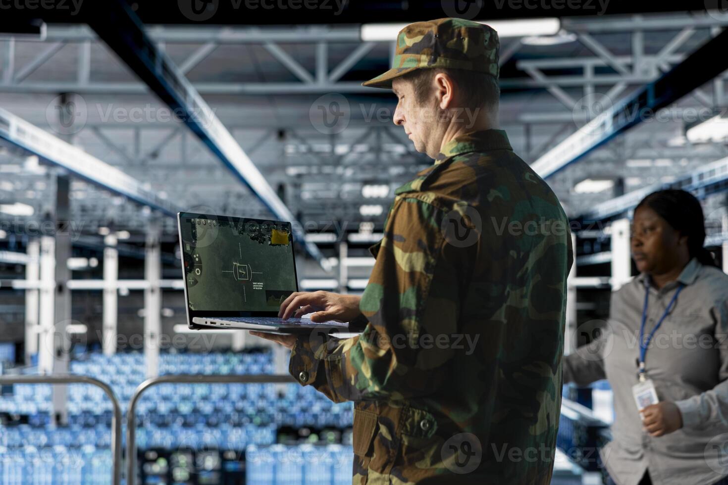 Data center army officer in uniform types commands on laptop keyboard ...