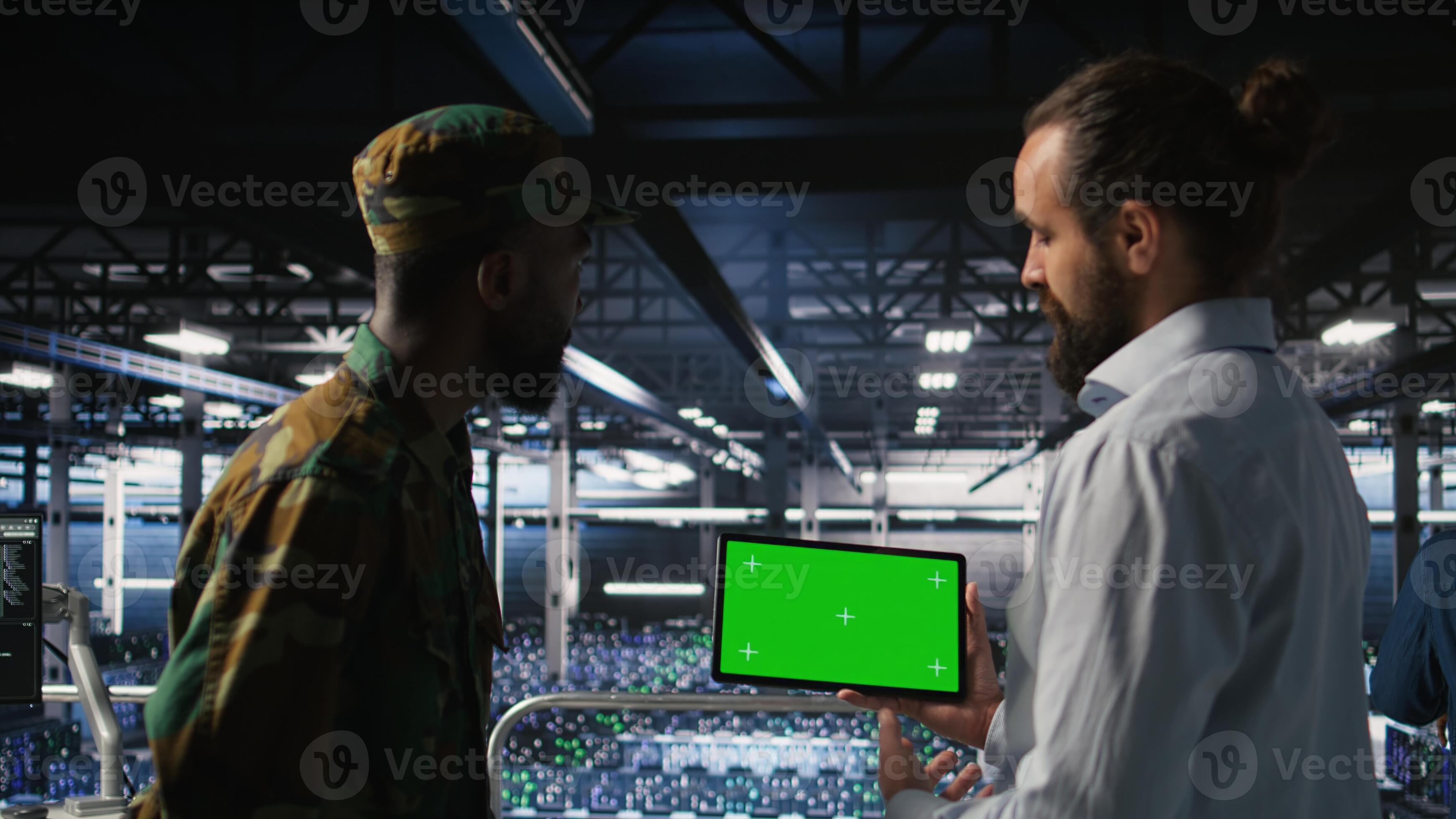 Military technicians in data center use green screen mockup tablet to monitor systems. Army ...