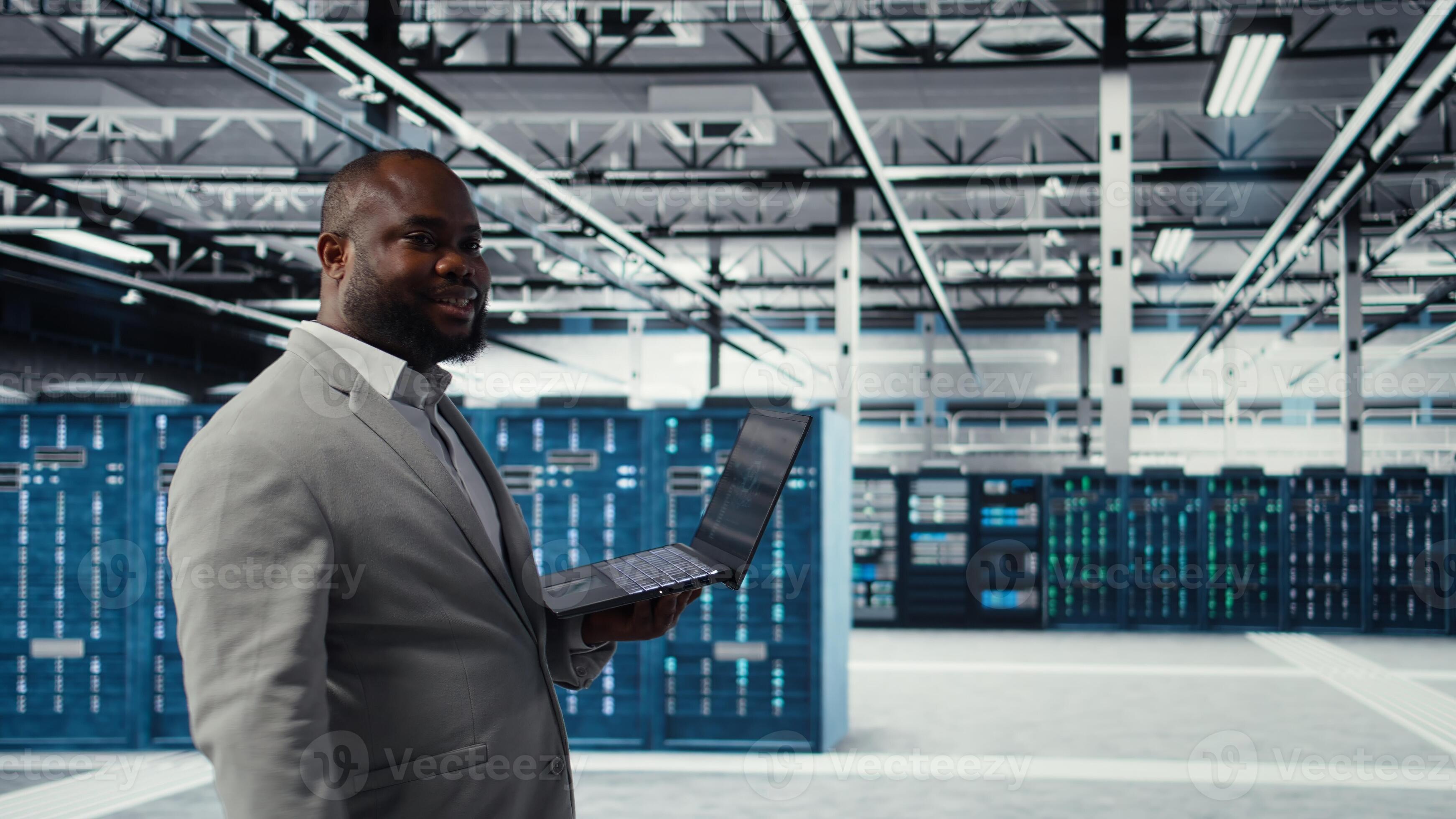 Data center engineer deploying AI driven management tools using laptop. Server farm employee ...