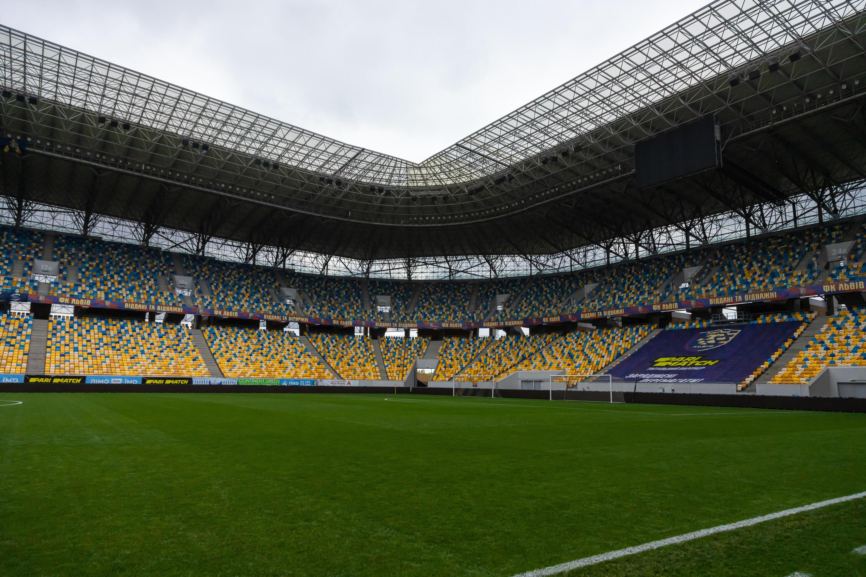 capturing the meticulously maintained pitch of a football stadium alongside its vast, tiered ...