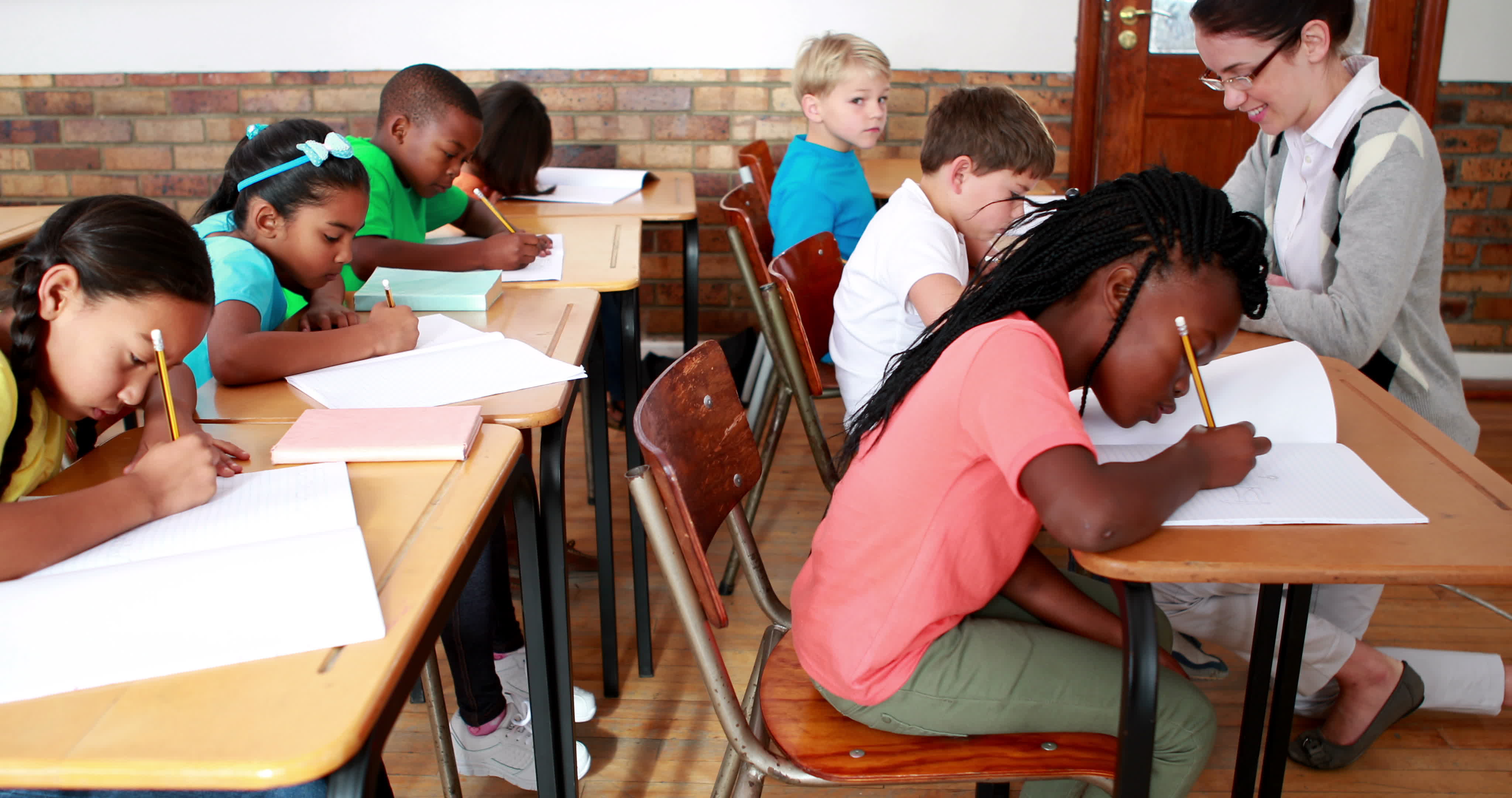 Pupils working hard during class with teacher smiling at camera 1287116 ... Pupils working hard during class with teacher smiling at camera 1287116 ...