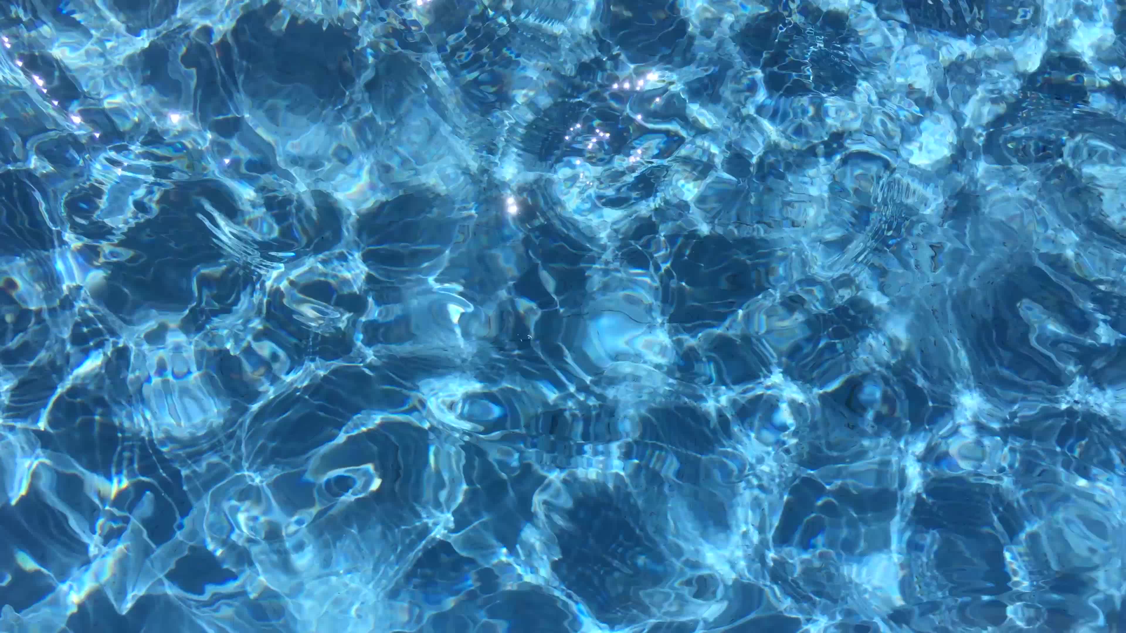 Light being reflected in the ripples of water in a swimming pool 4K ...