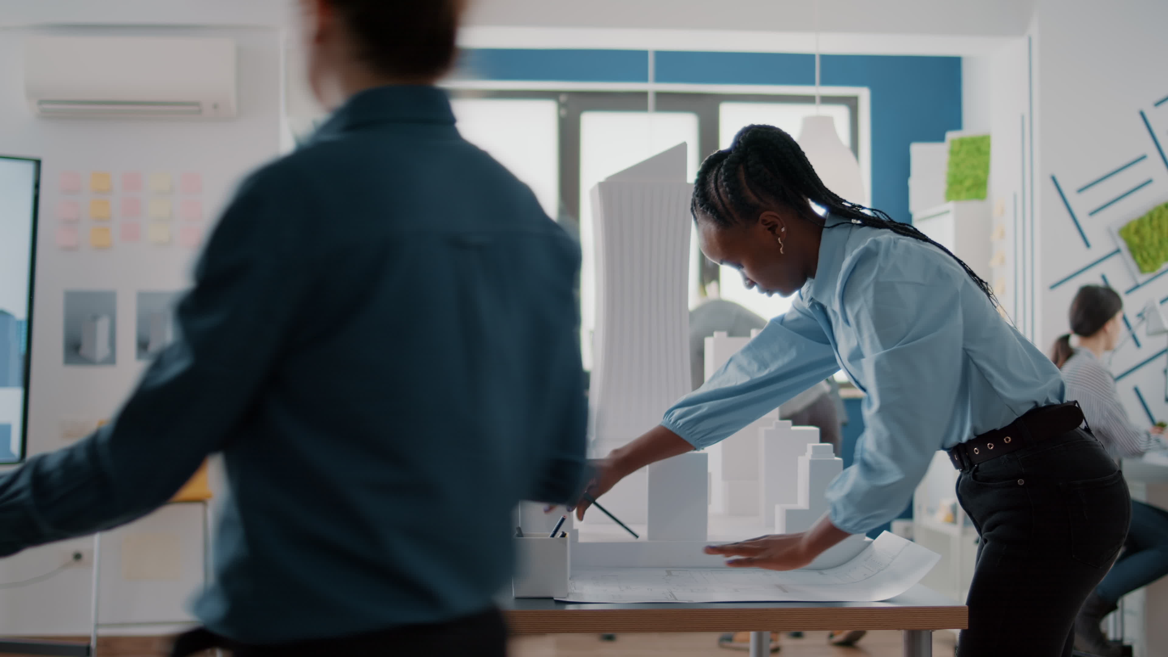 Handheld Shot Of Architect Analyzing Blueprints Plan And Building Model To Create Project