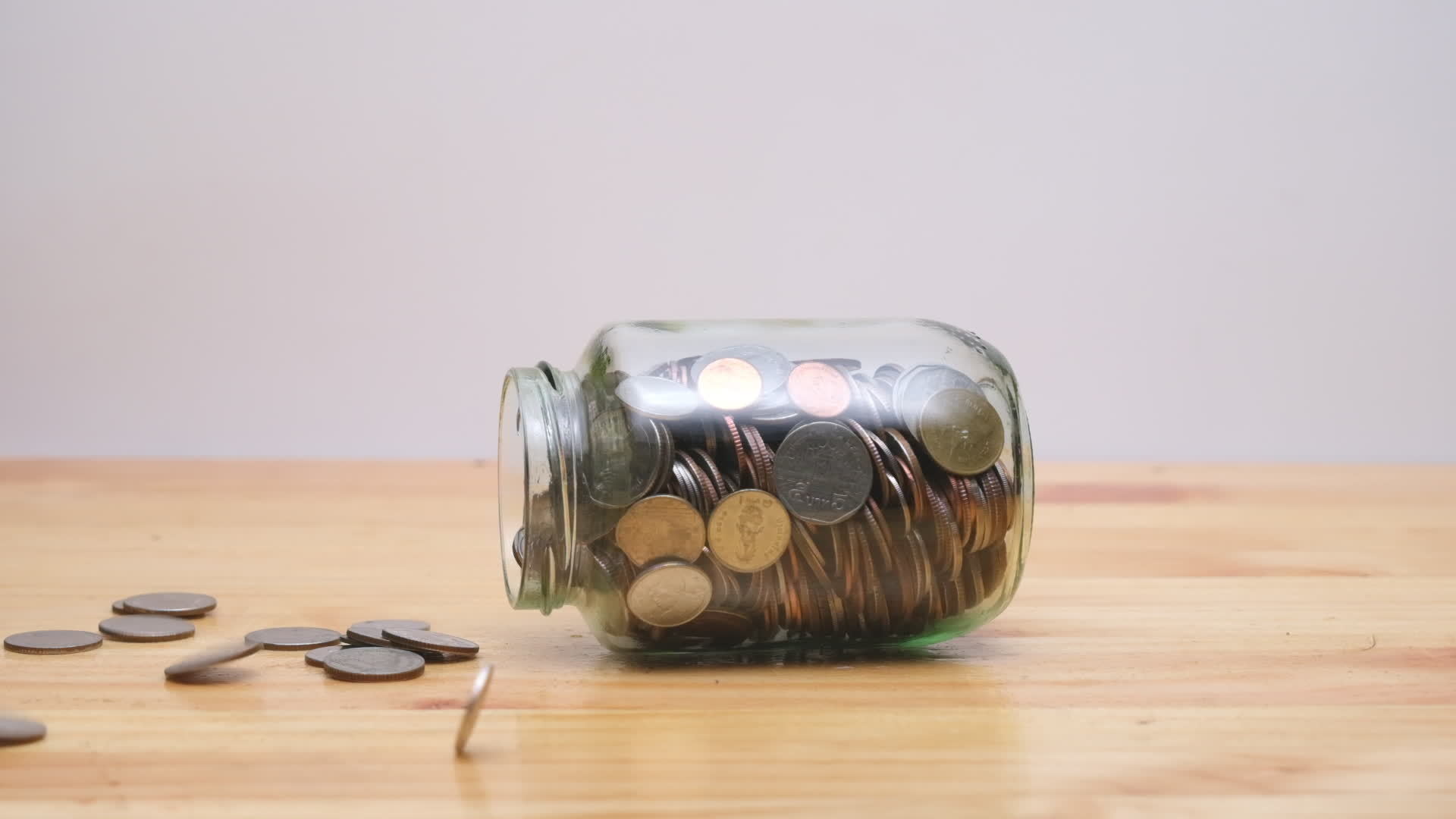 In Slow Motion The Coin Slipped From The Falling Glass Jar On The Wooden Table Financial
