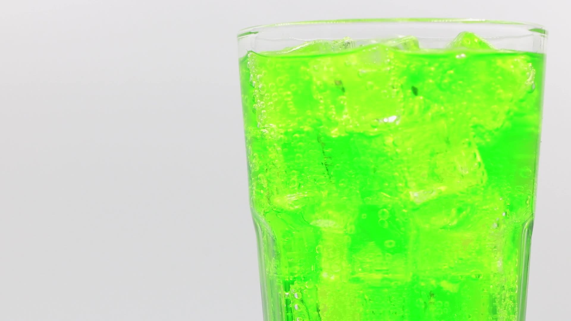 Green sparkling water with Ice in glass. Green sparkling water drink over white background ...