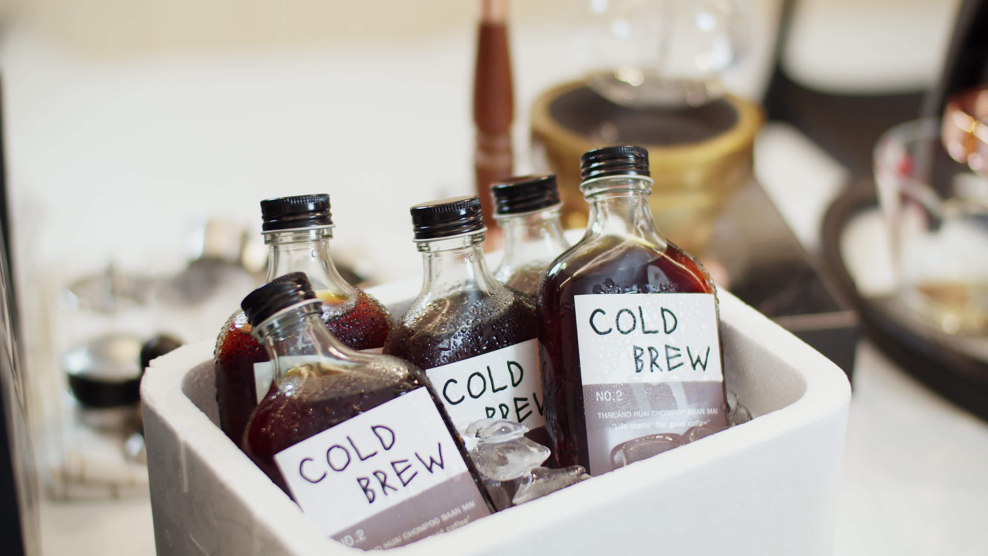 Coffee shop corner with bottled cold brew coffee soaked in ice buckets. 4k Slow Motion video ...