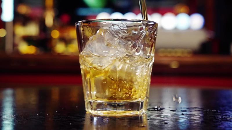 a glass of whiskey . ice cubes fall into the glass 10991719 Stock Video at Vecteezy