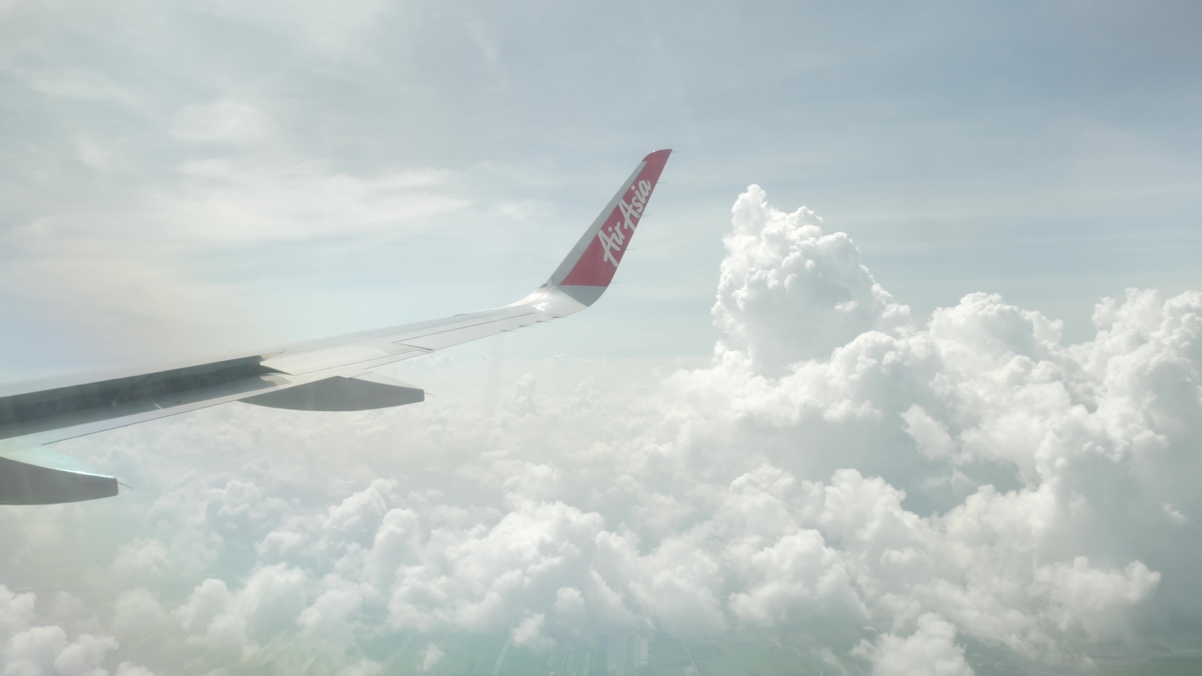 View of the airaisa airbus a320 plane wing through the airplane window flying over the cloud ...