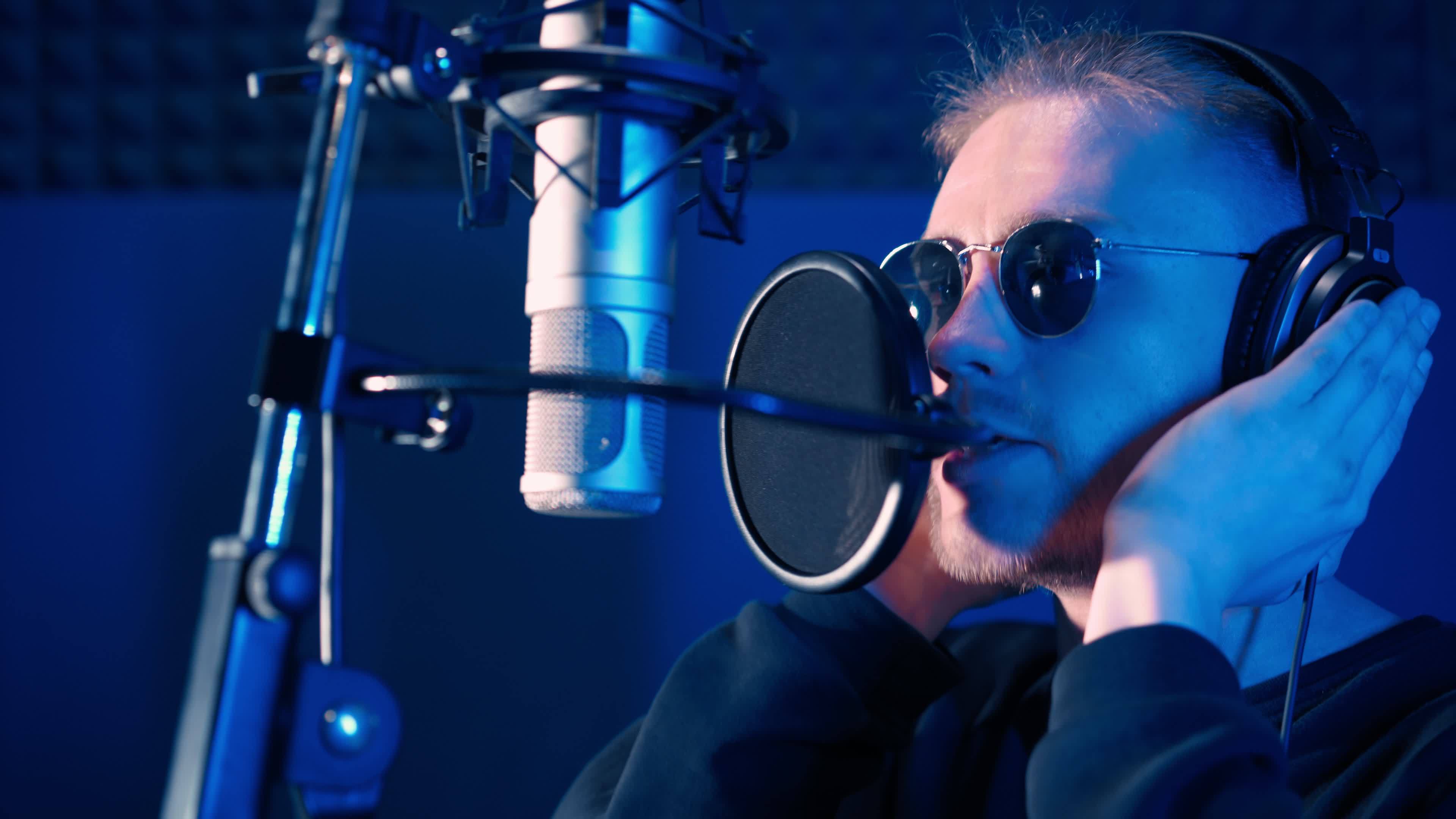 Male Rap Singer with Headphones Sings Hip Hop into a Microphone ...